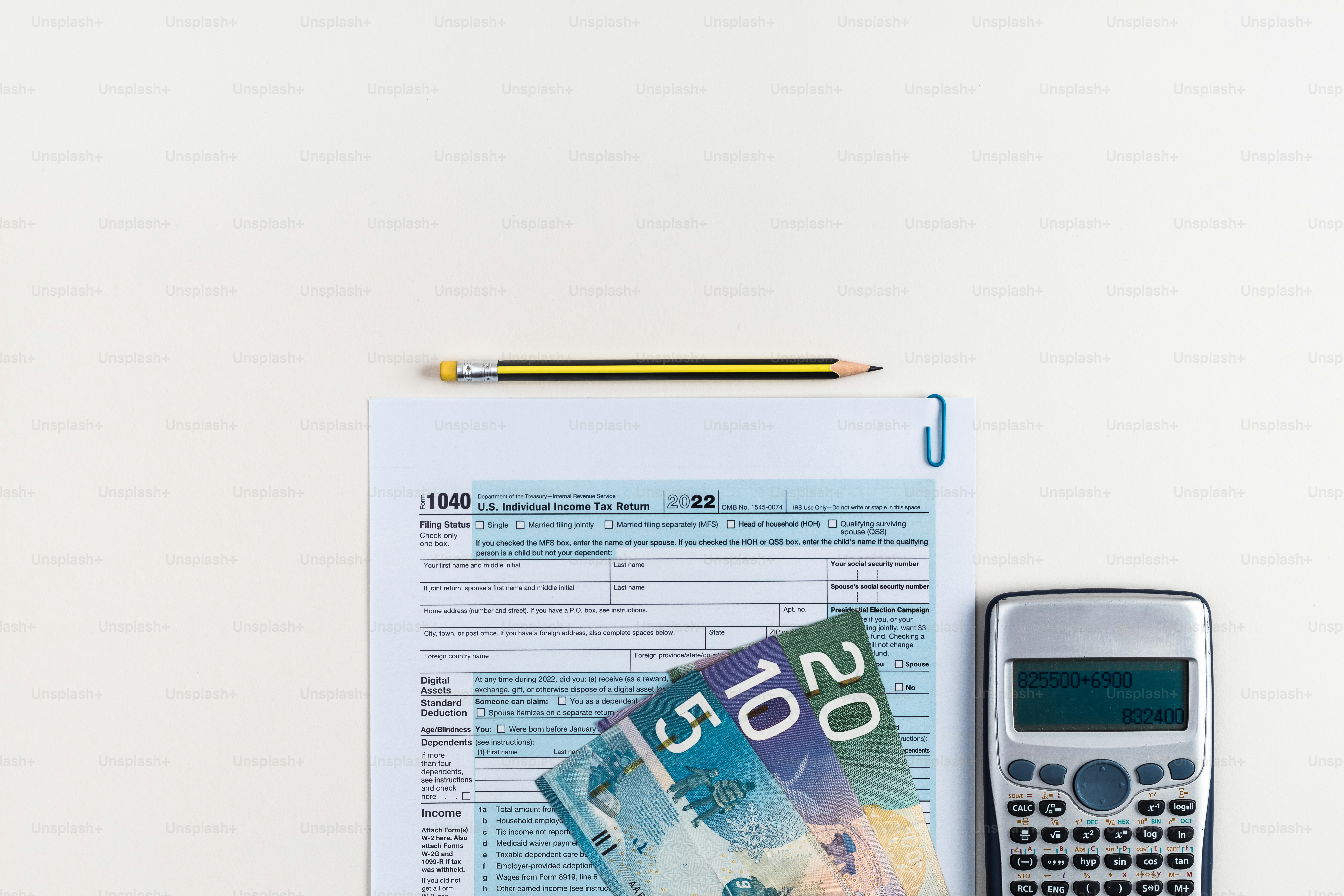 A tax form next to a calculator and a pen photo – Finance Image on Unsplash