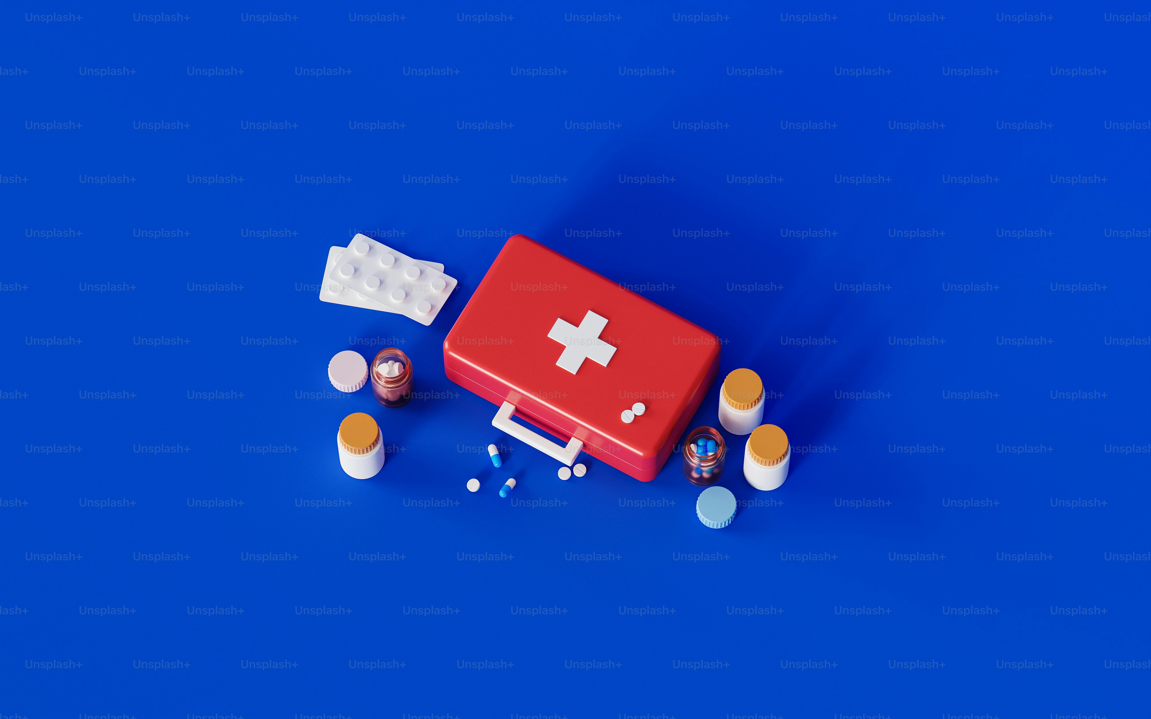 A red first aid kit sitting on top of a blue surface photo – Wallpaper ...