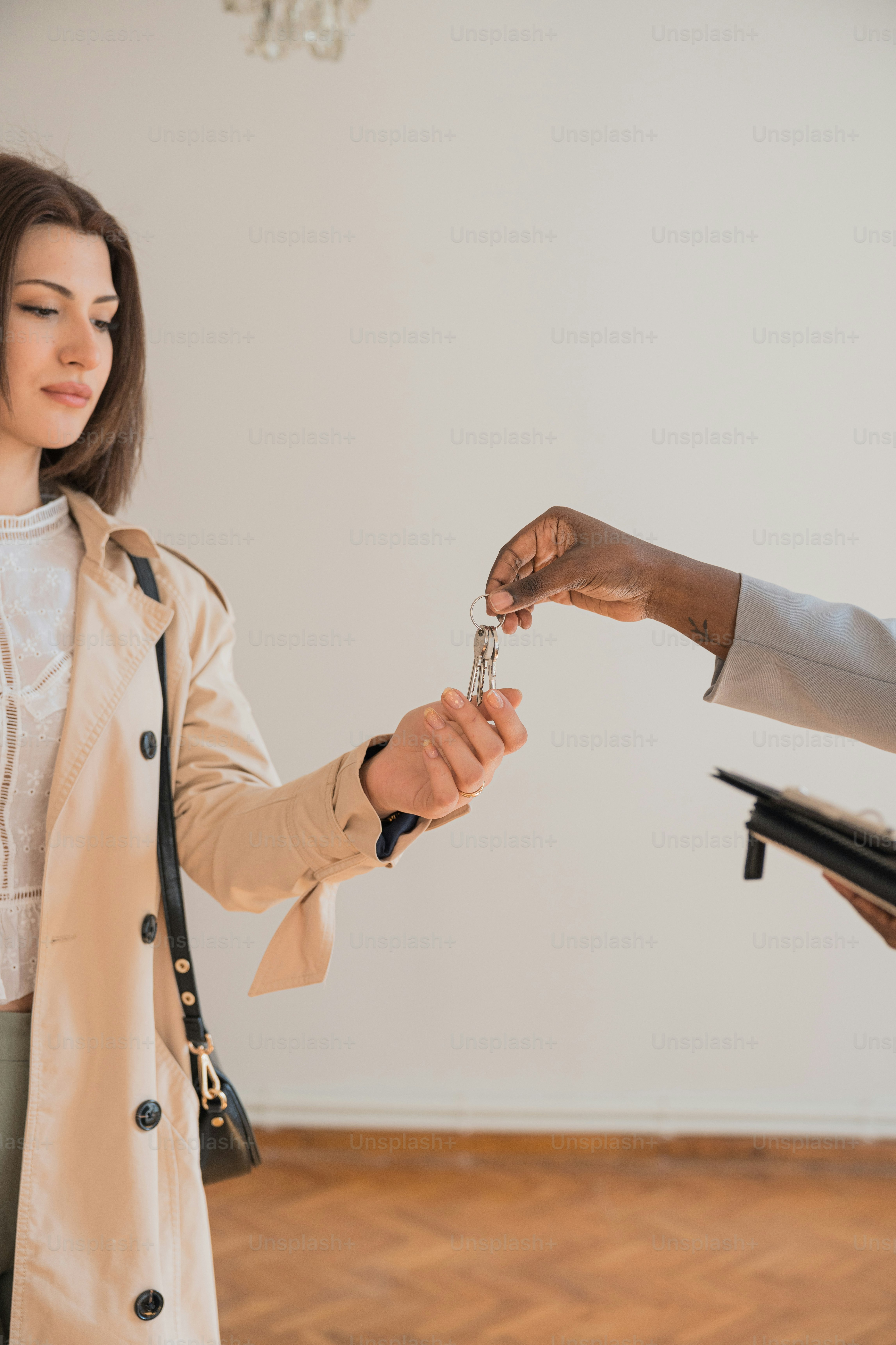 A woman holding a key to another woman's hand photo – House keys Image ...