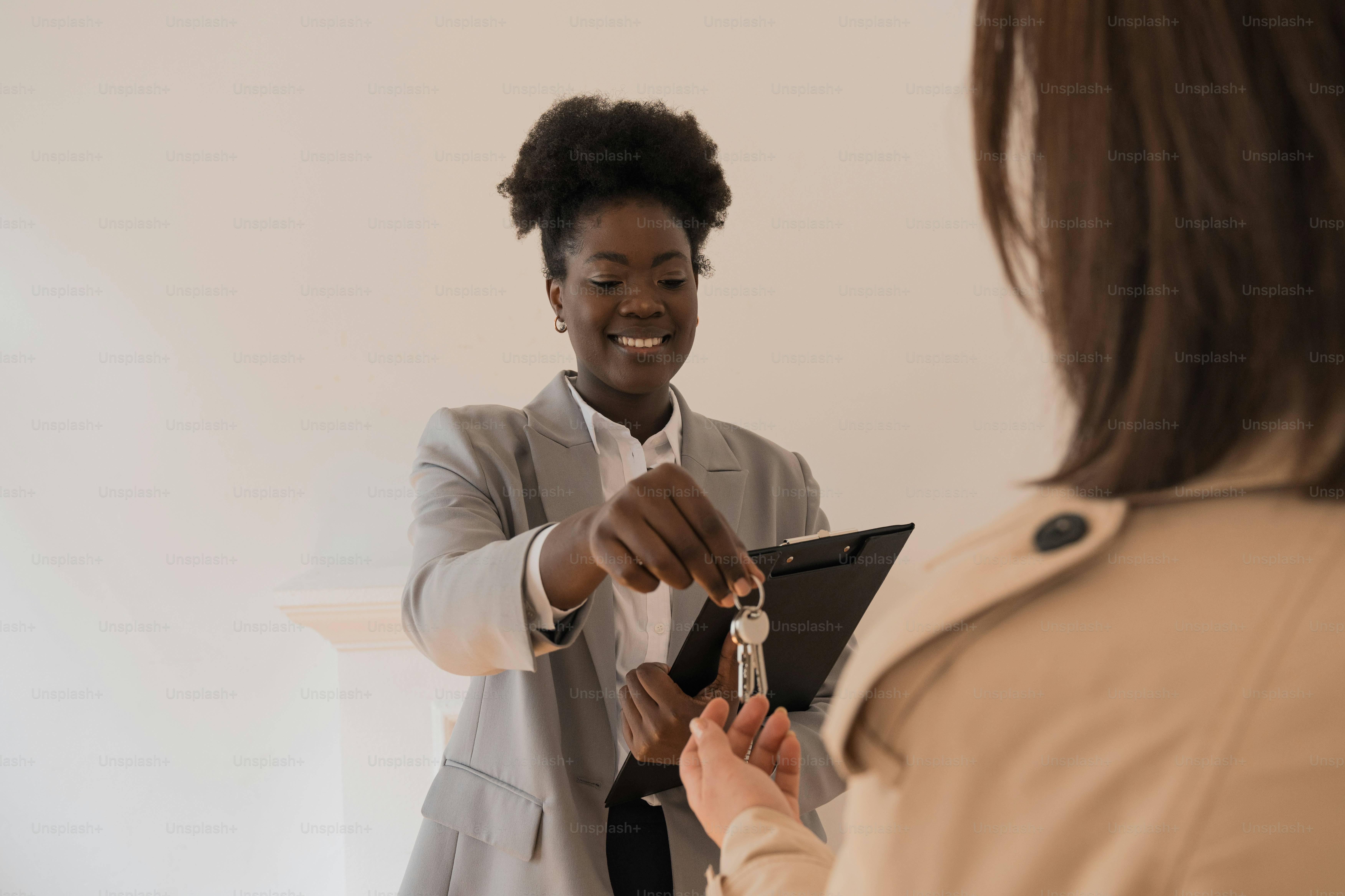 A woman is handing a woman a key photo – Buying a house Image on Unsplash