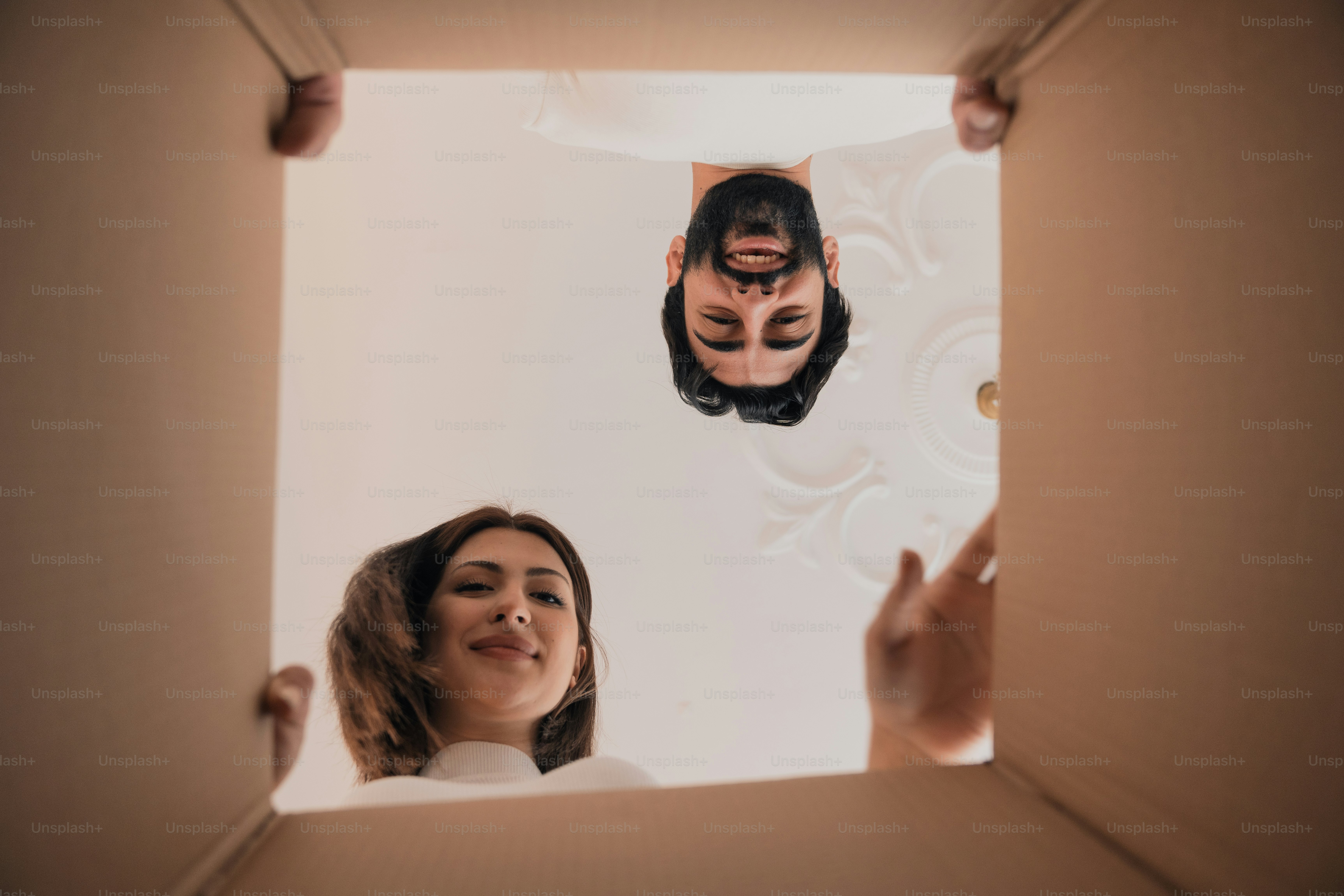 A man and a woman looking at each other through a box photo – Home ...