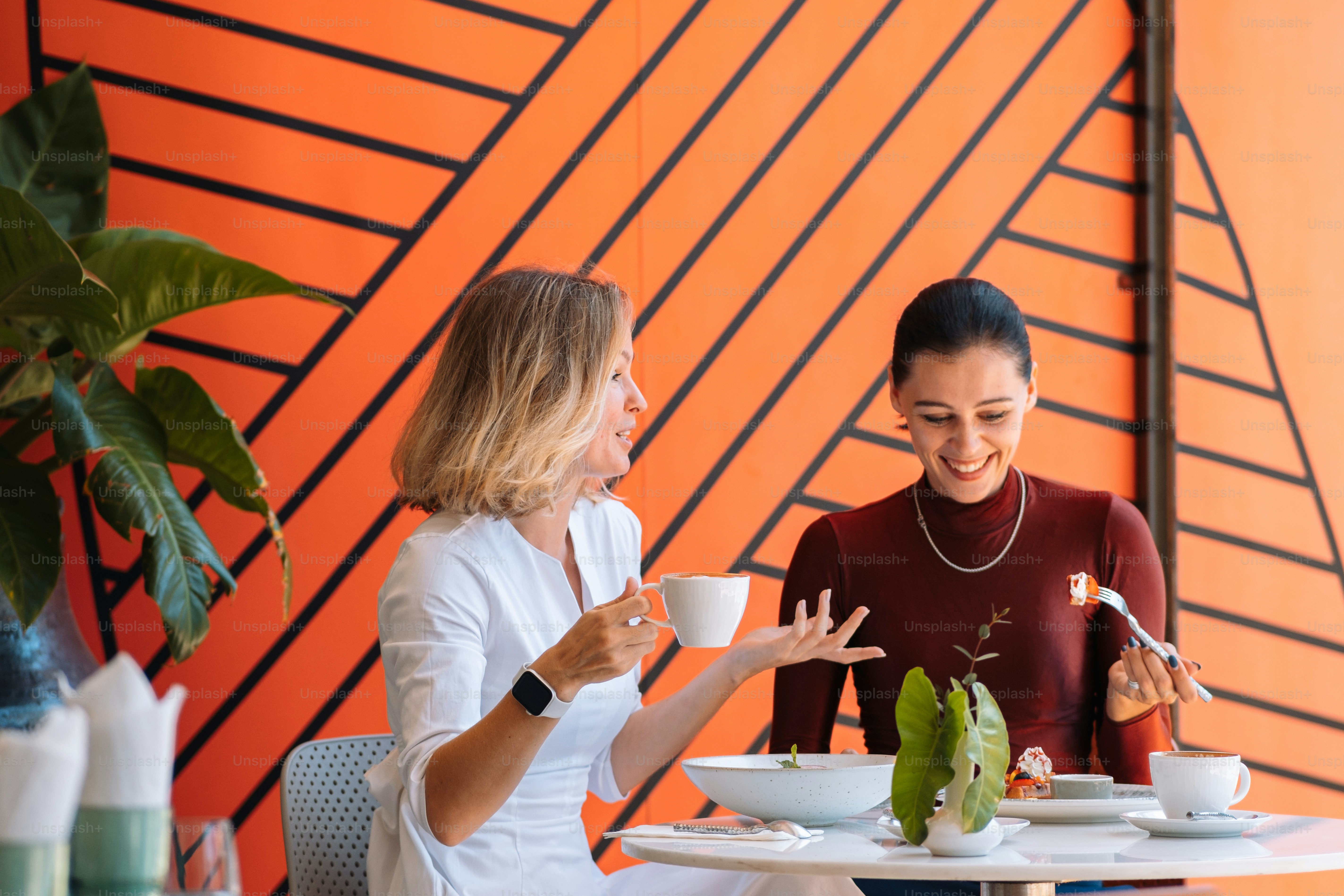 Un couple de femmes assises à une table en train de manger photo ...