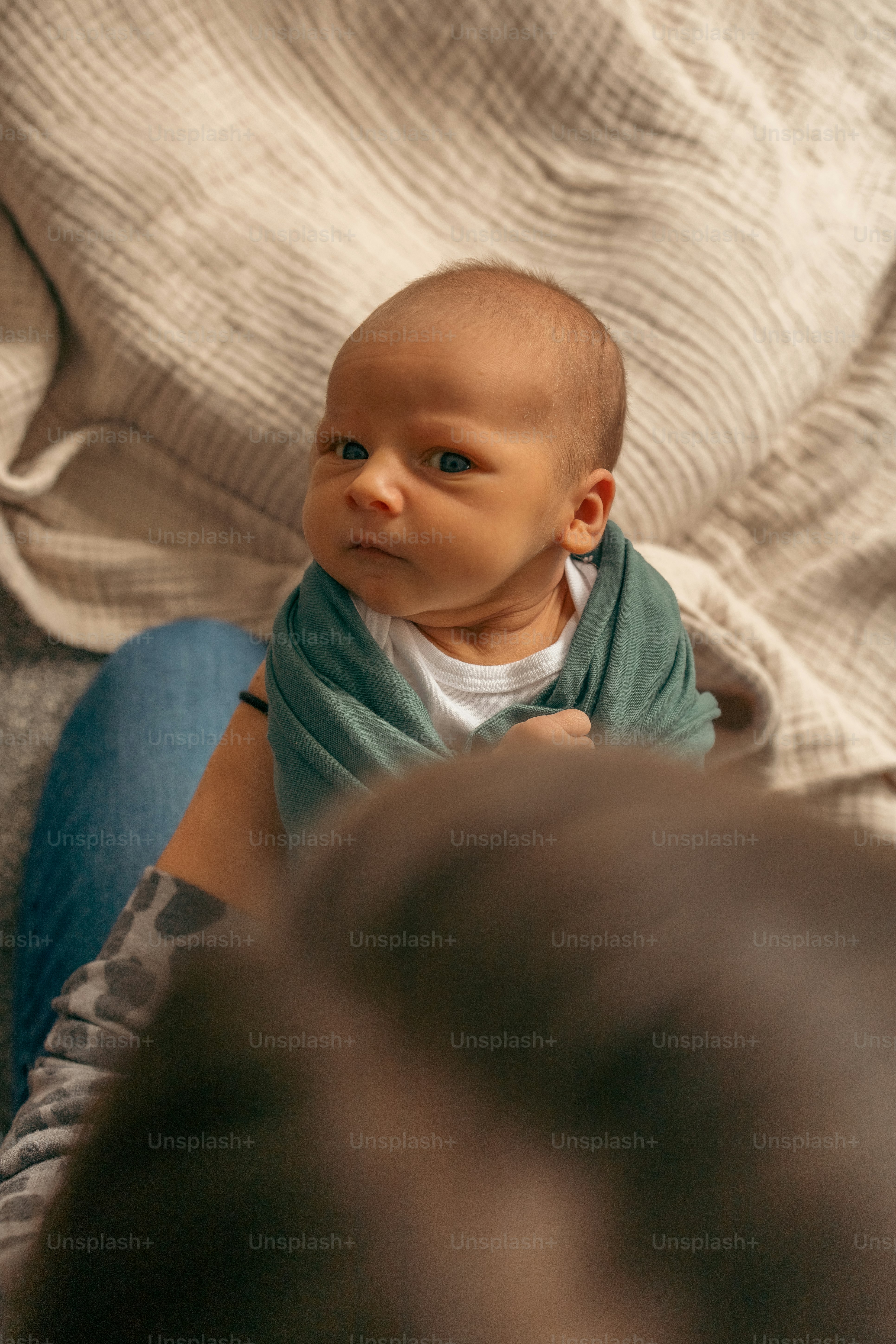 Foto Um bebê com um babador sentado em um sofá – Imagem de Recém ...