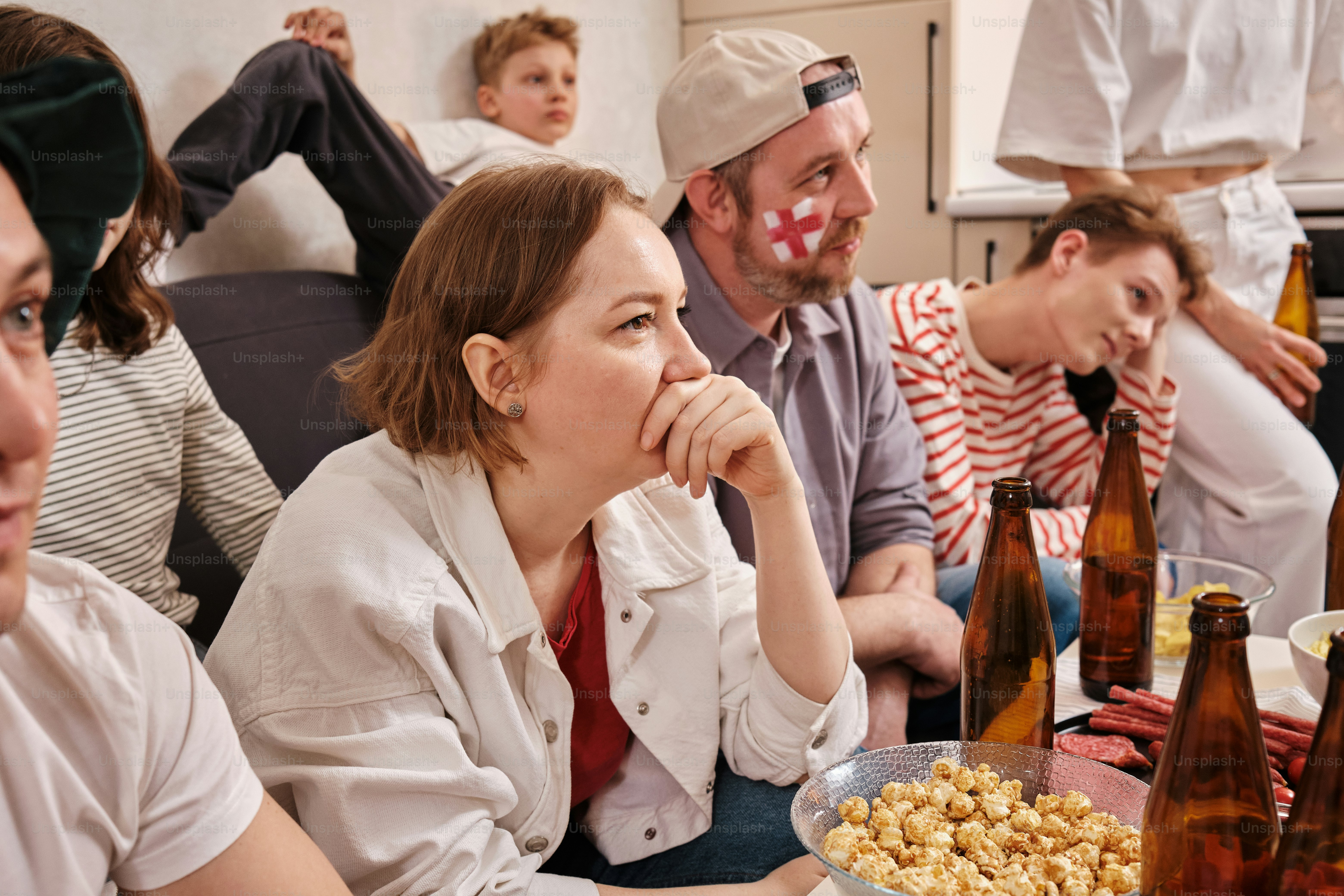 A group of people sitting around a table with bottles of beer photo ...