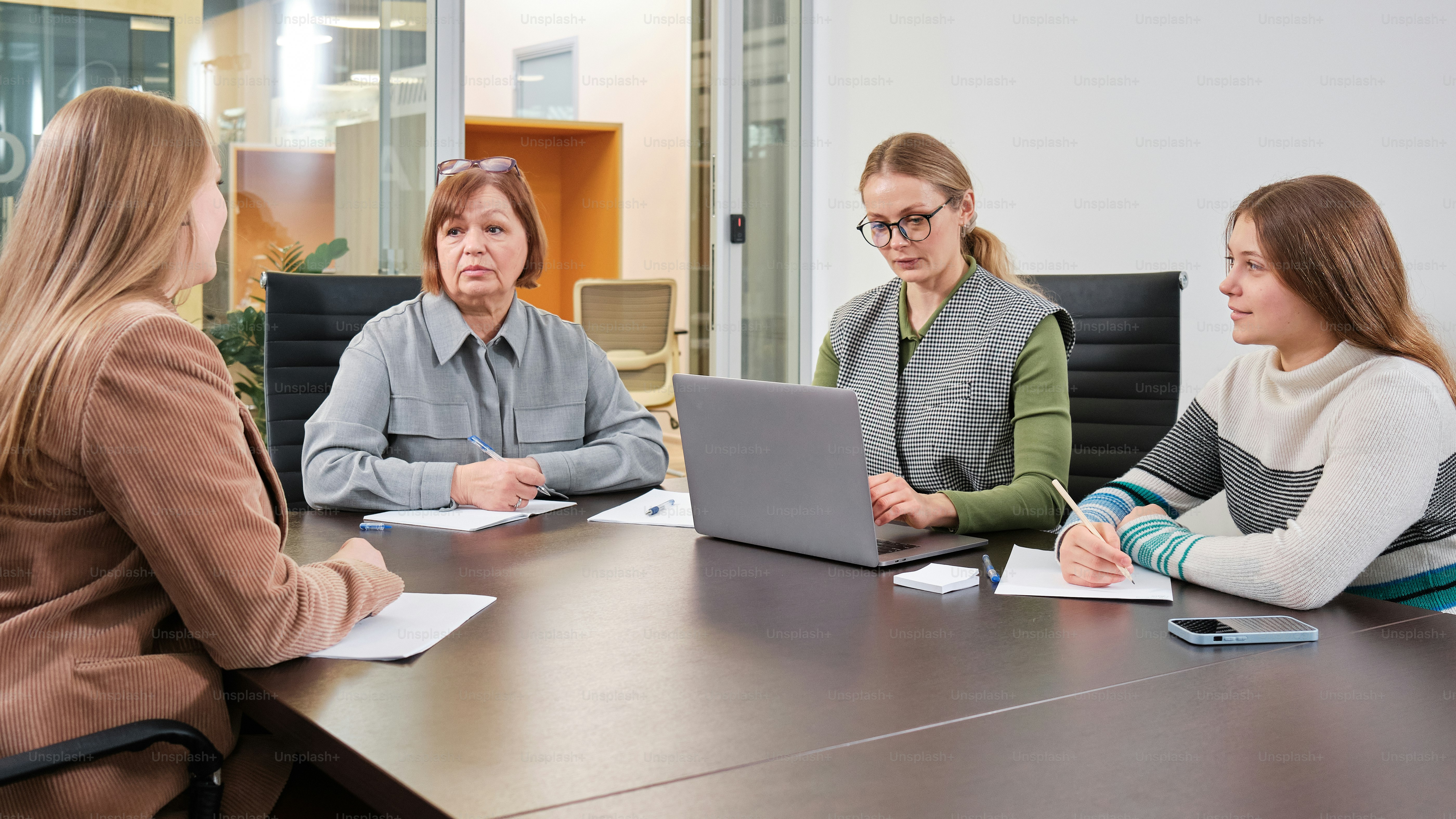 A group of women sitting around a table photo – Handshake Image on Unsplash