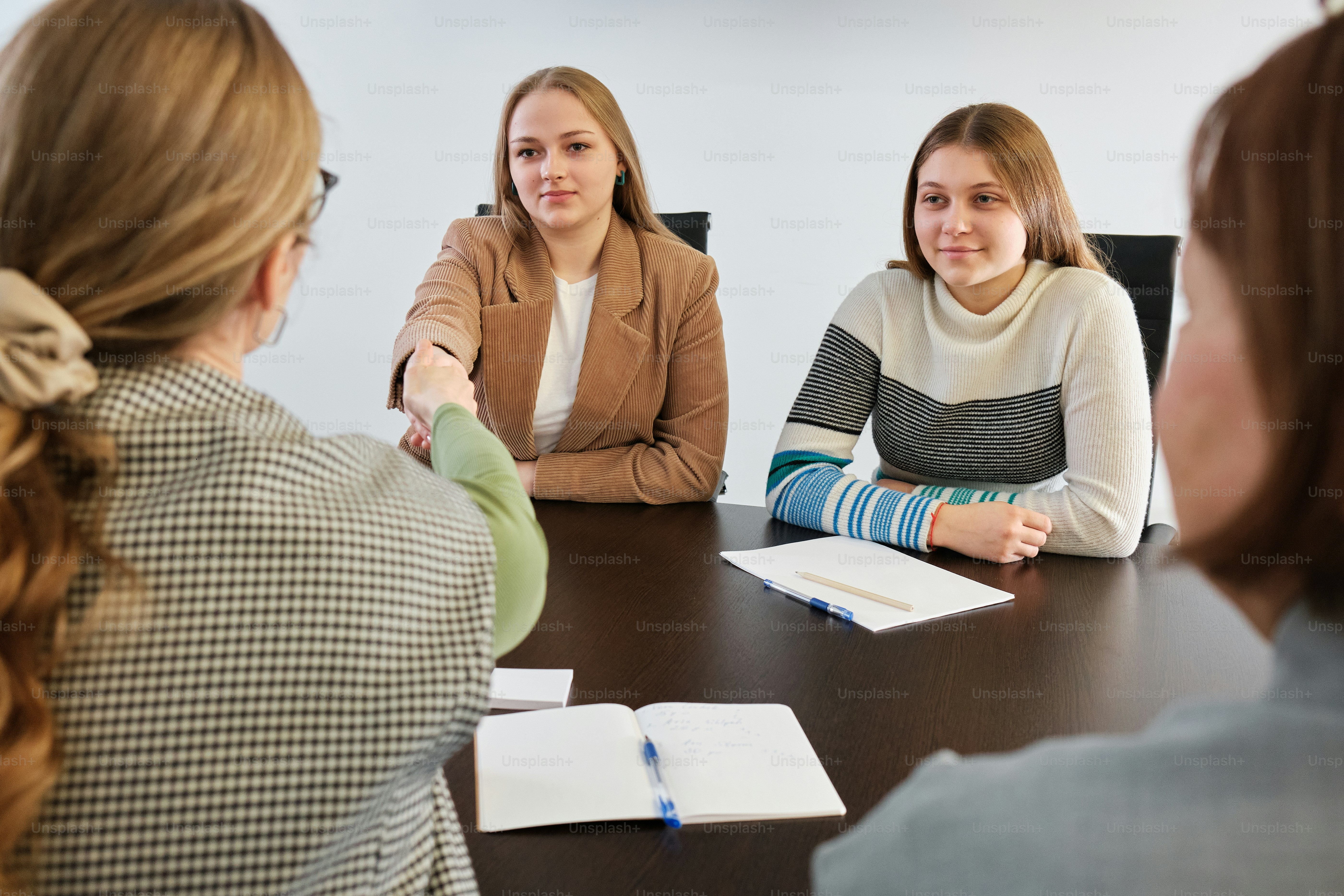 A group of women sitting around a table talking photo – Job interview ...