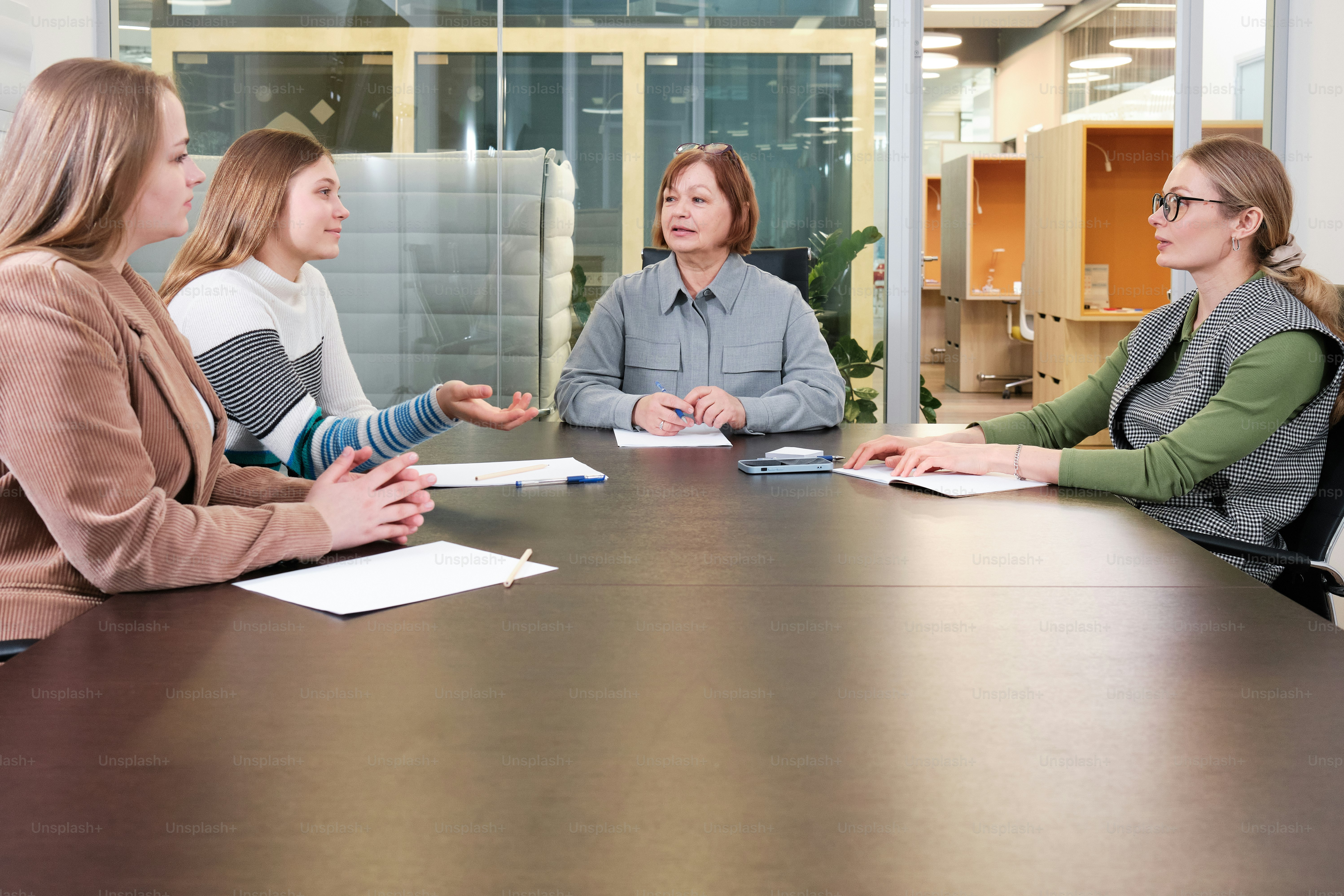 A group of women sitting around a conference table photo – Hiring Image ...
