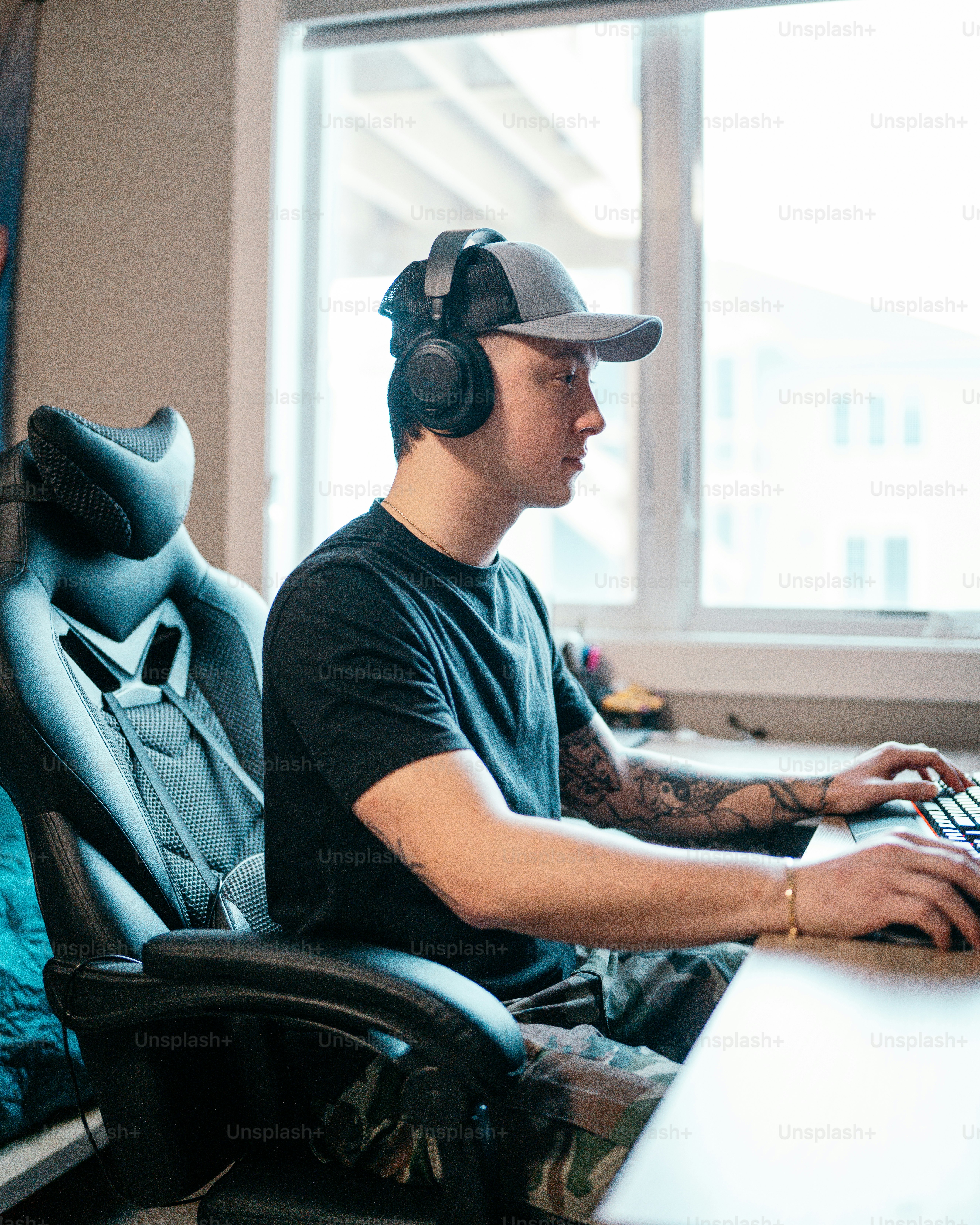 A man sitting in front of a computer wearing headphones photo – Console ...