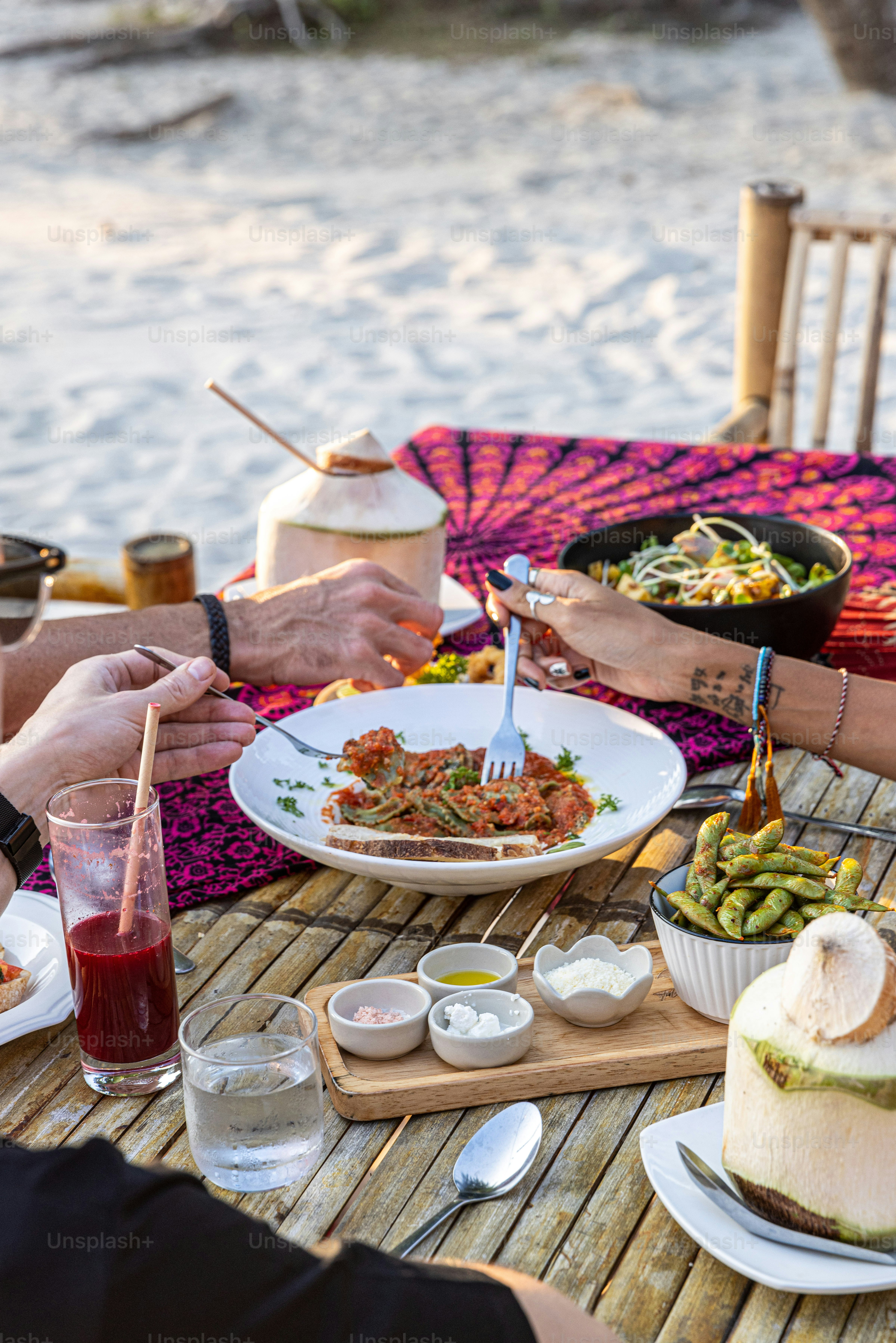 Un grupo de personas sentadas alrededor de una mesa comiendo alimentos ...