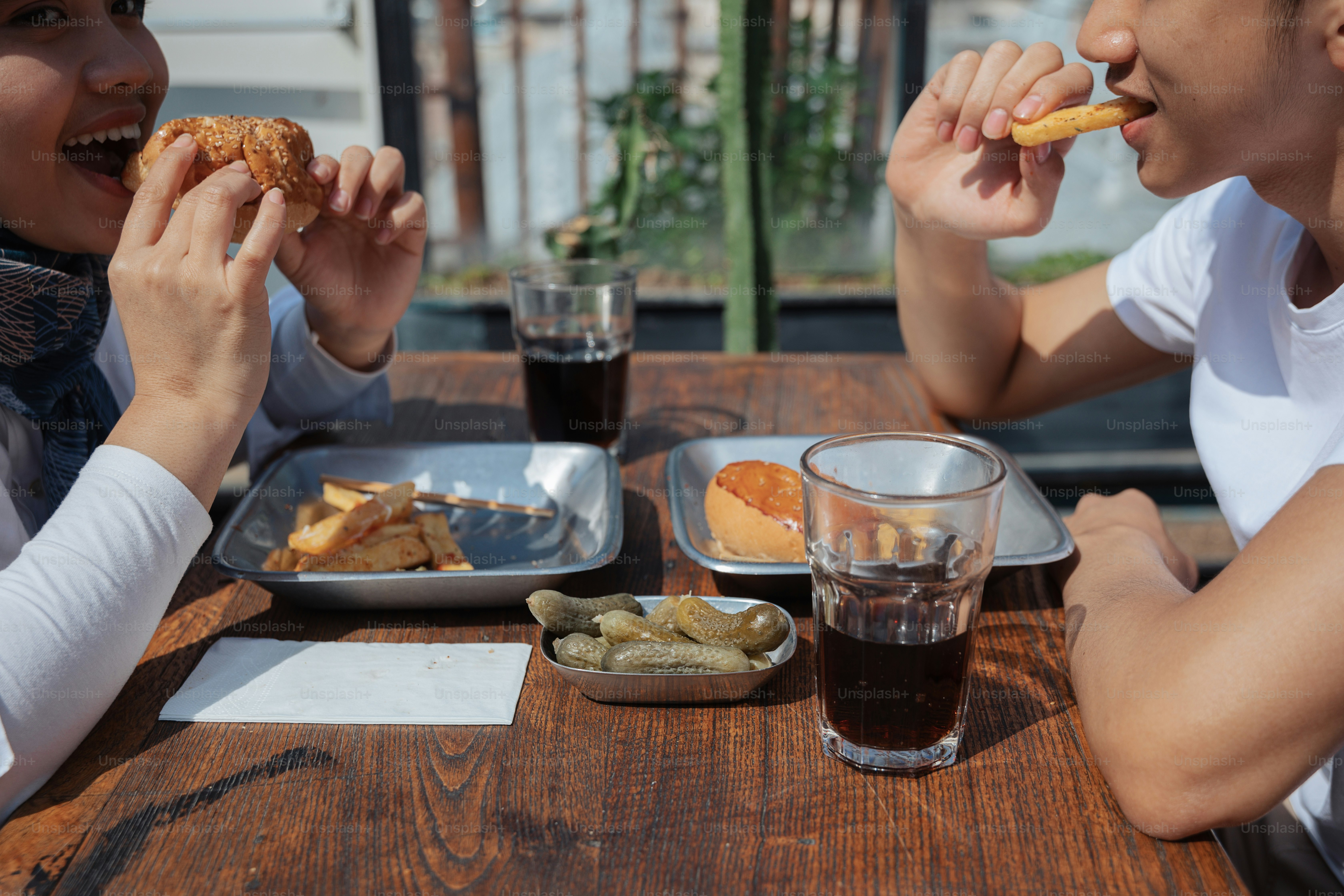 Un couple de personnes assises à une table en train de manger de la ...