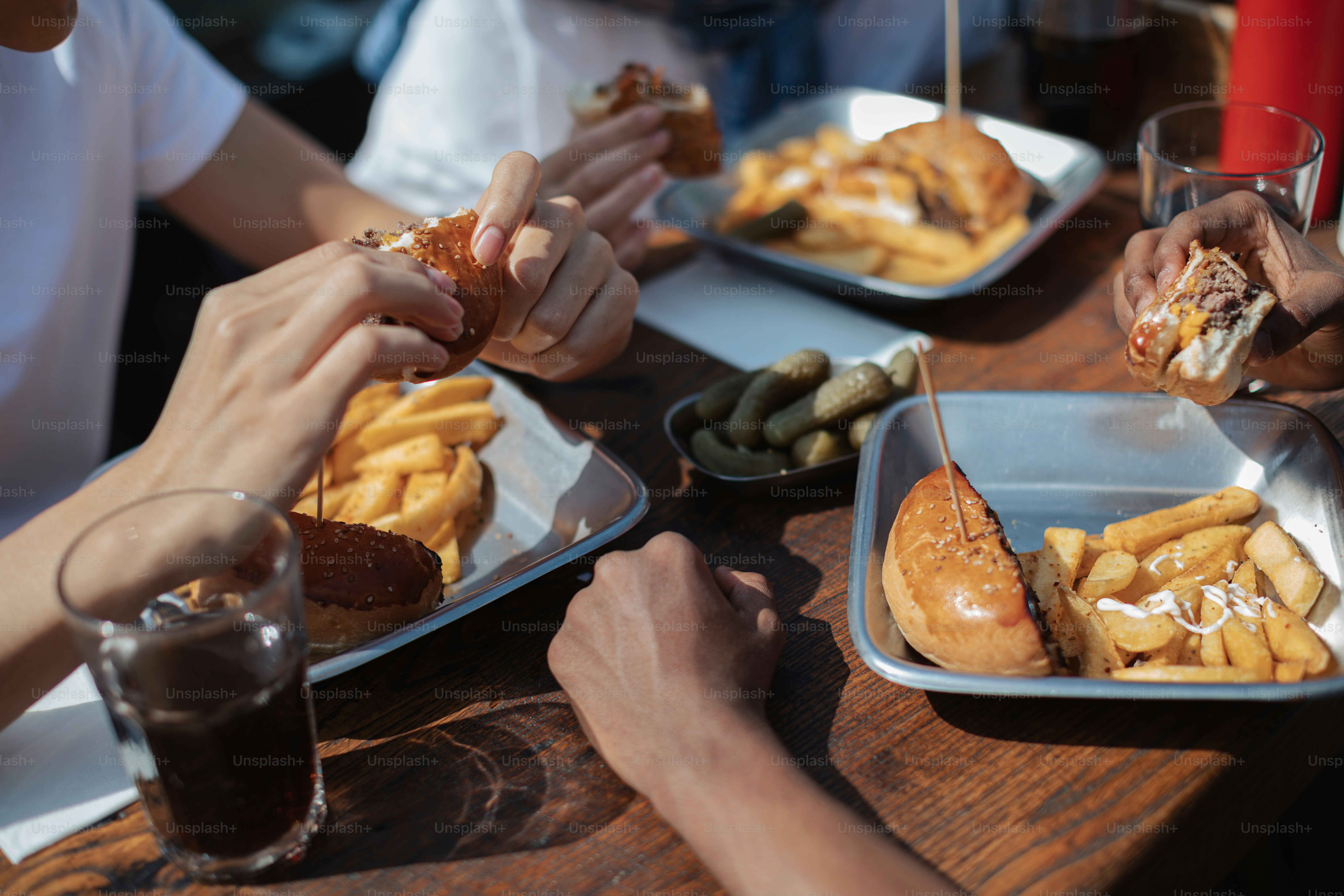 A man and a woman sitting at a table eating food photo – Food Image on ...