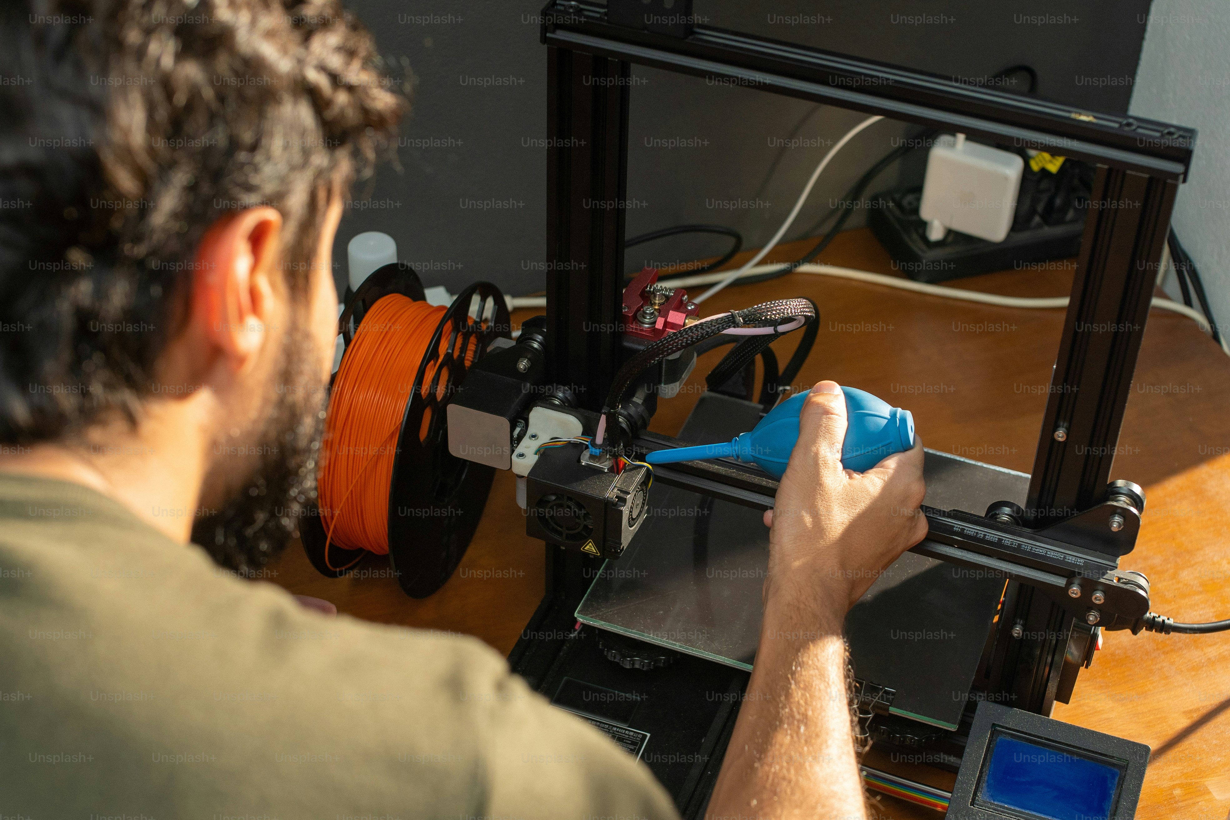 A man is working on a 3d printer photo – 3d print Image on Unsplash
