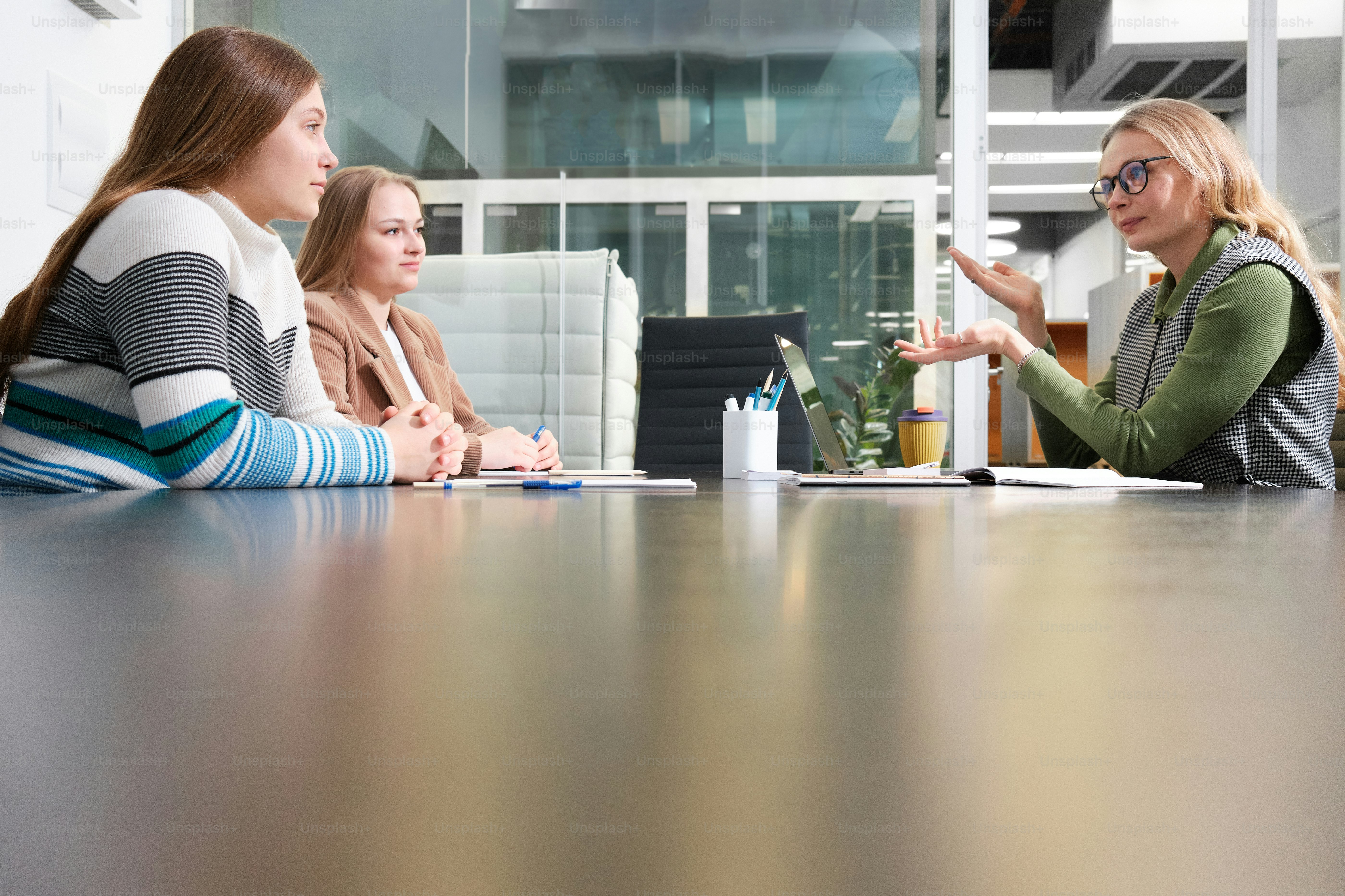 A group of women sitting around a table talking photo – Recruiter Image ...