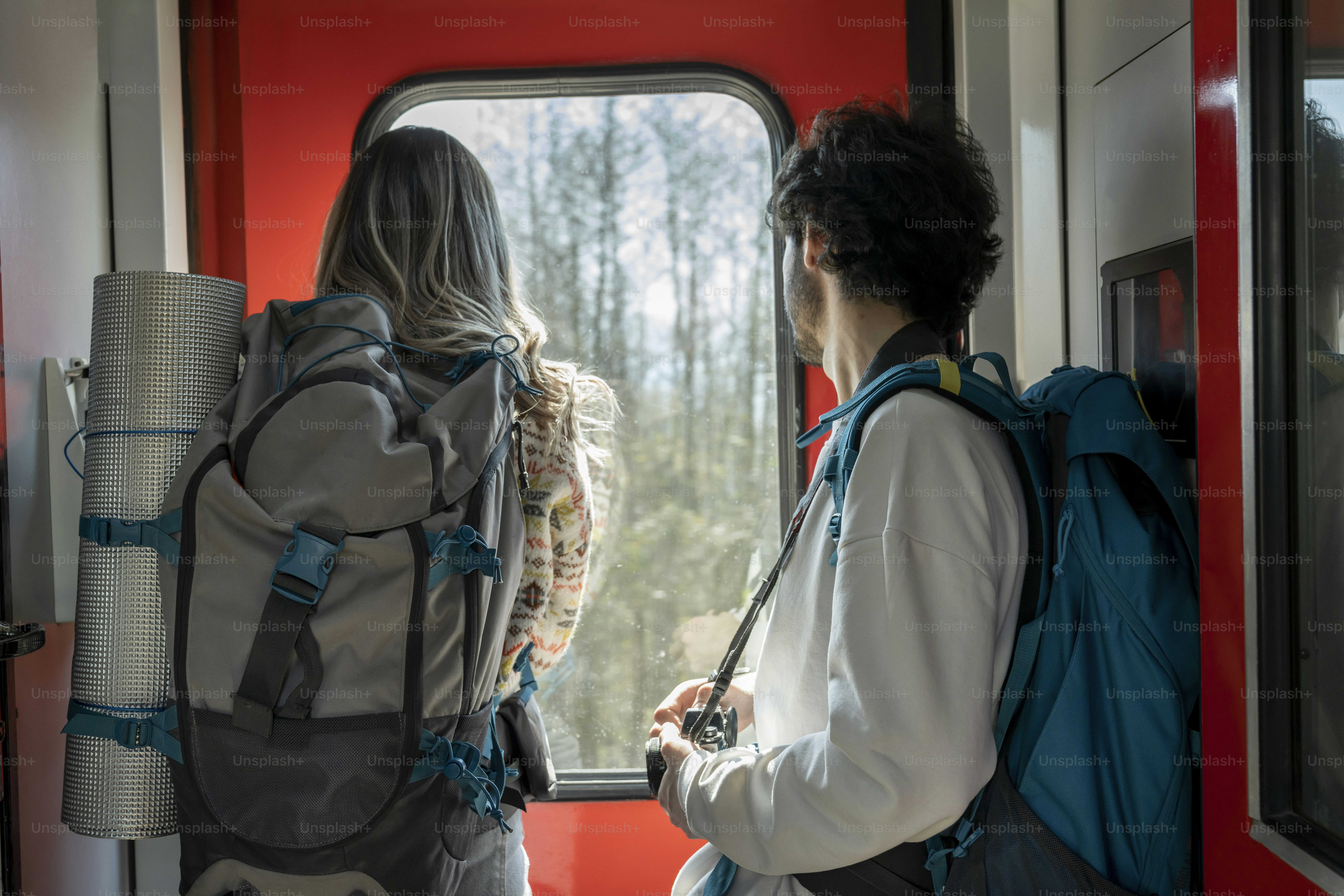 A man and a woman looking out a train window photo – Europe travel ...