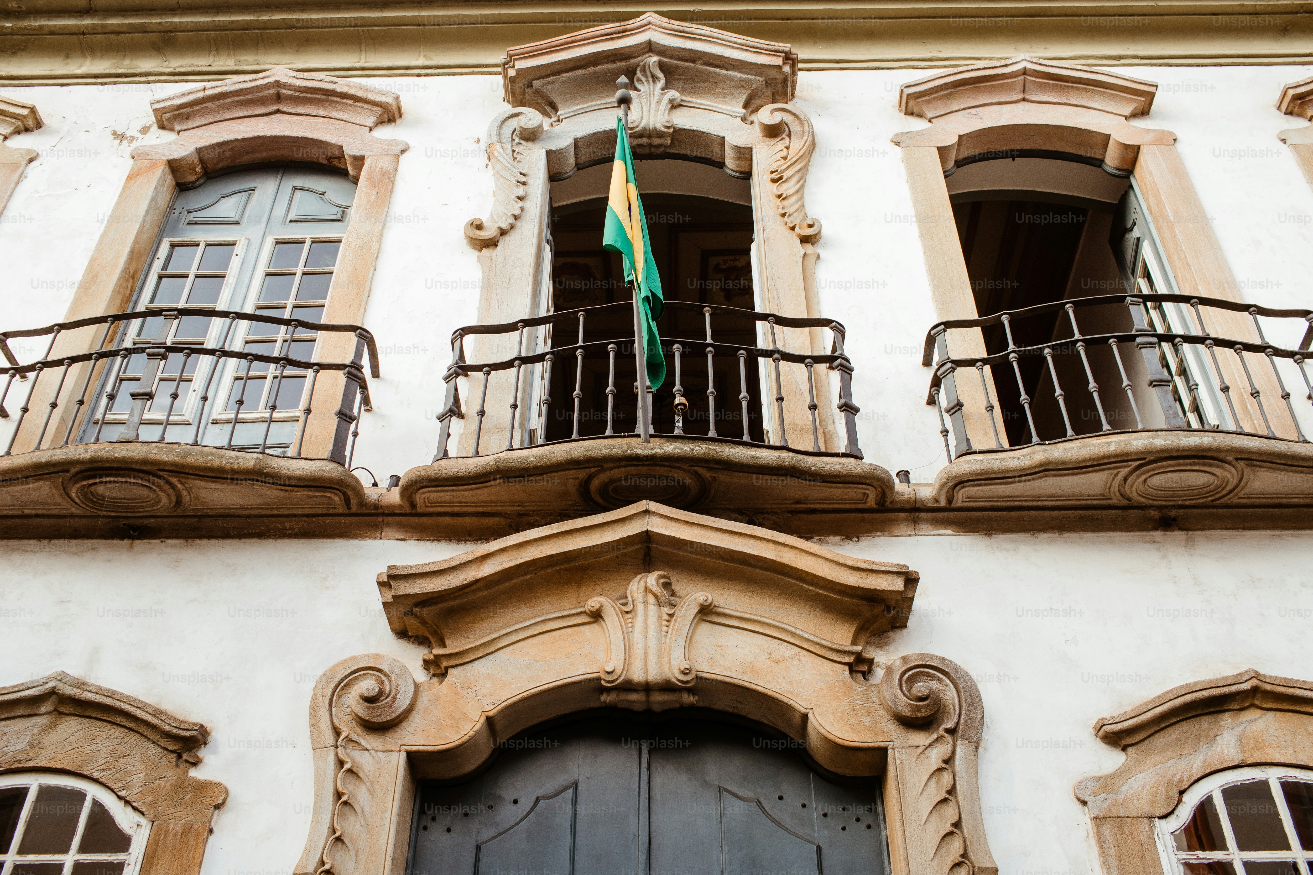 A building with two balconies and a green flag photo – Architecture ...