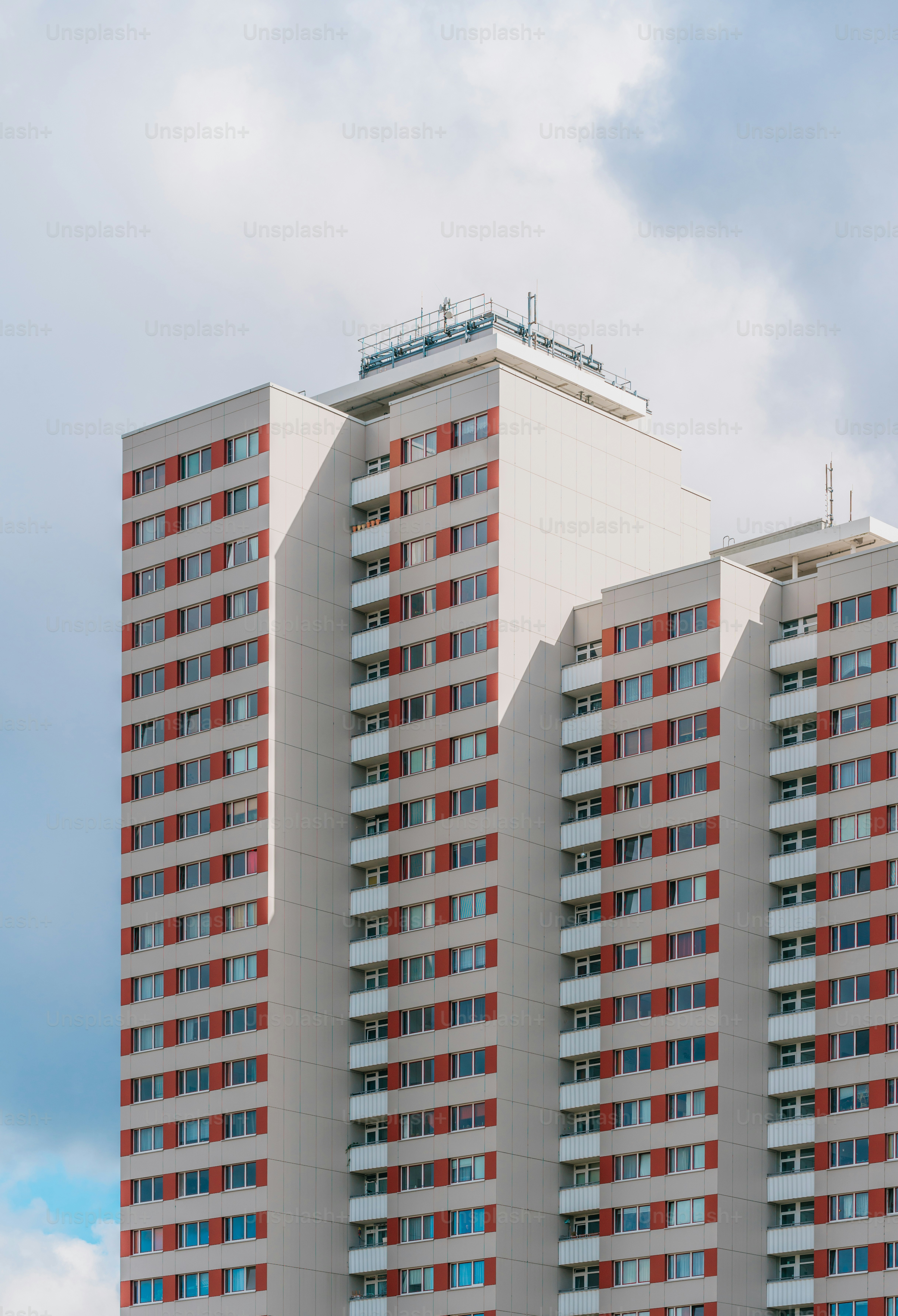 A tall red and white building with a sky background photo – Berlin ...