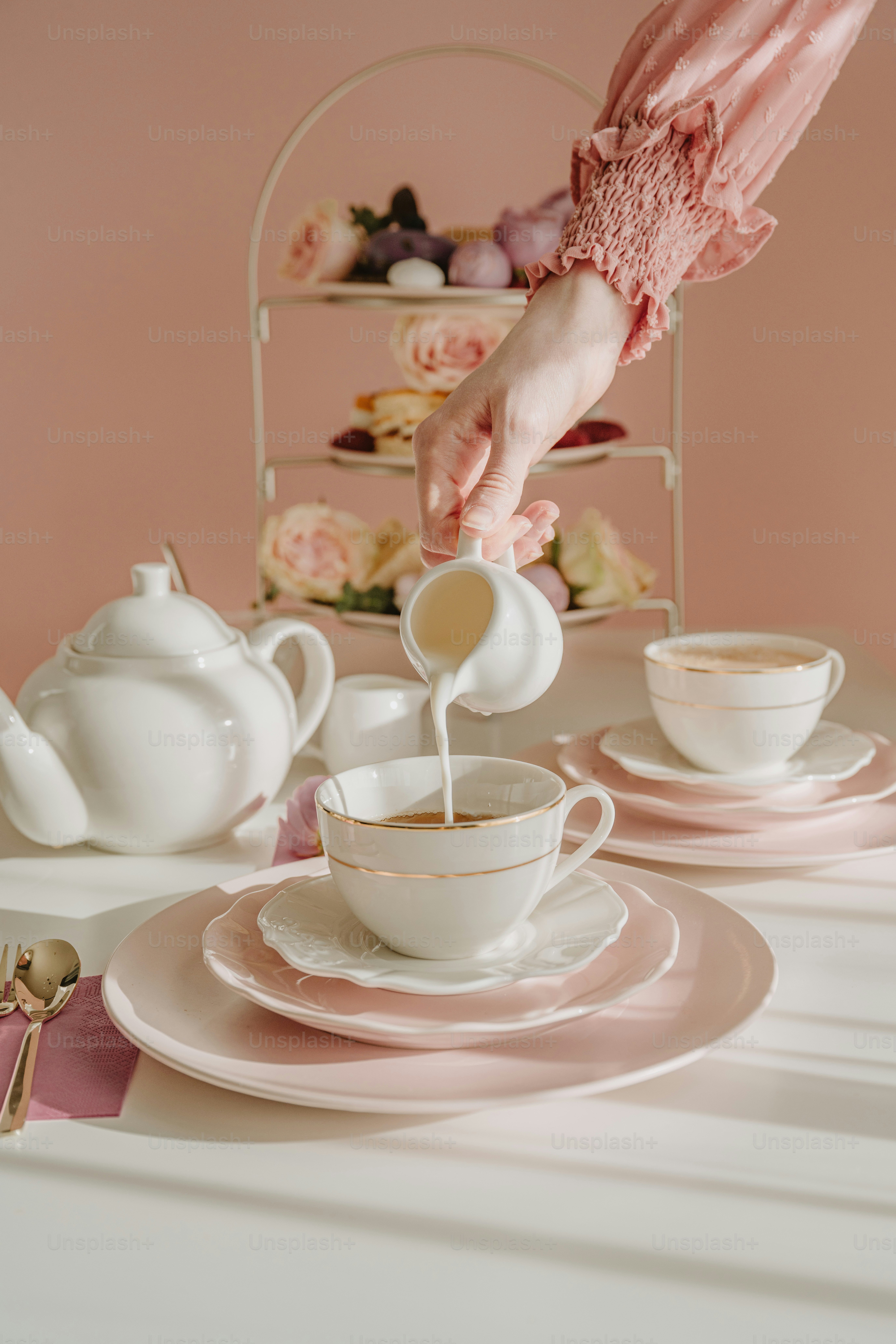 A person pouring tea into a cup on a table photo – Afternoon tea Image ...