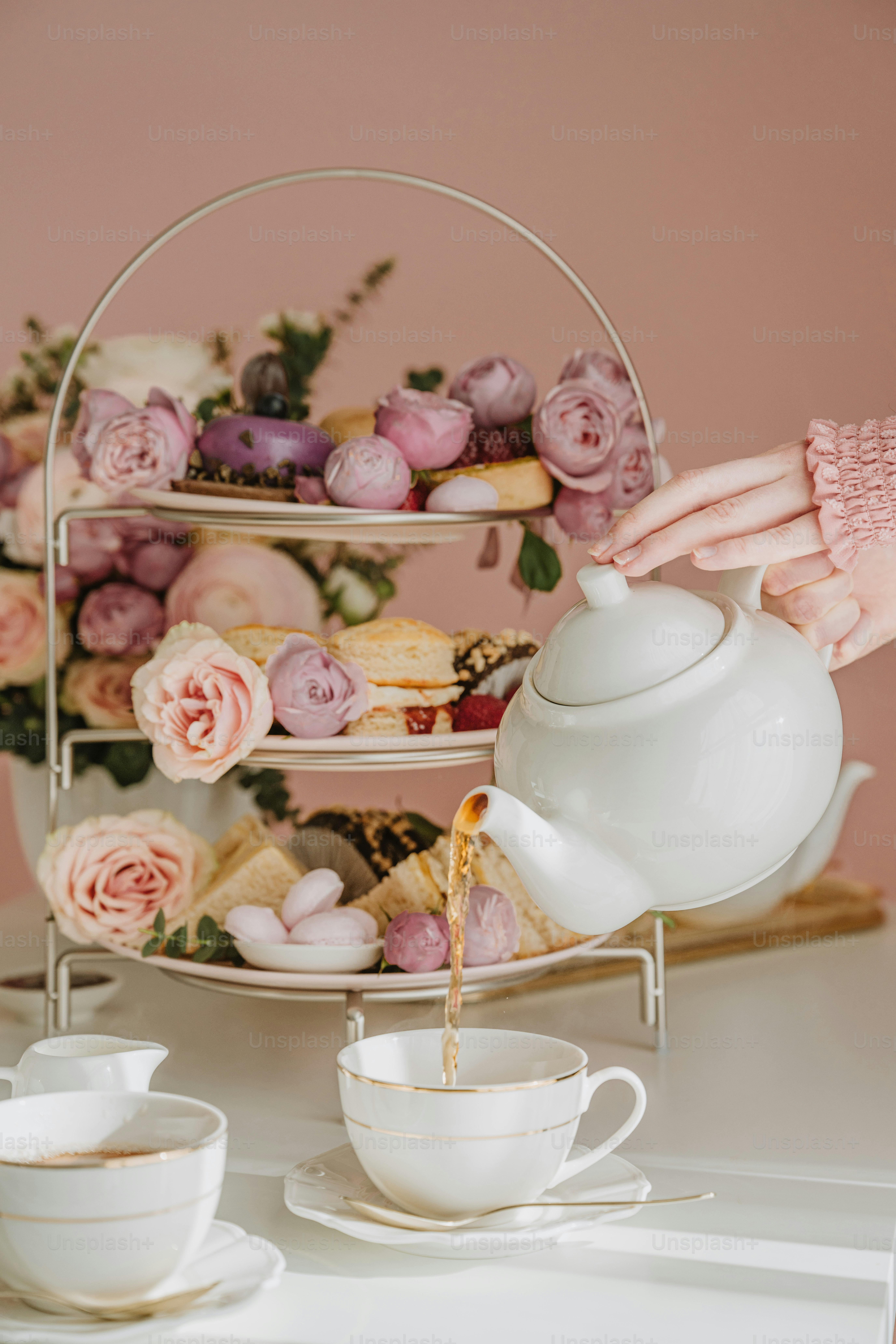 A person pouring tea into a cup on a table photo – Tea party Image on ...