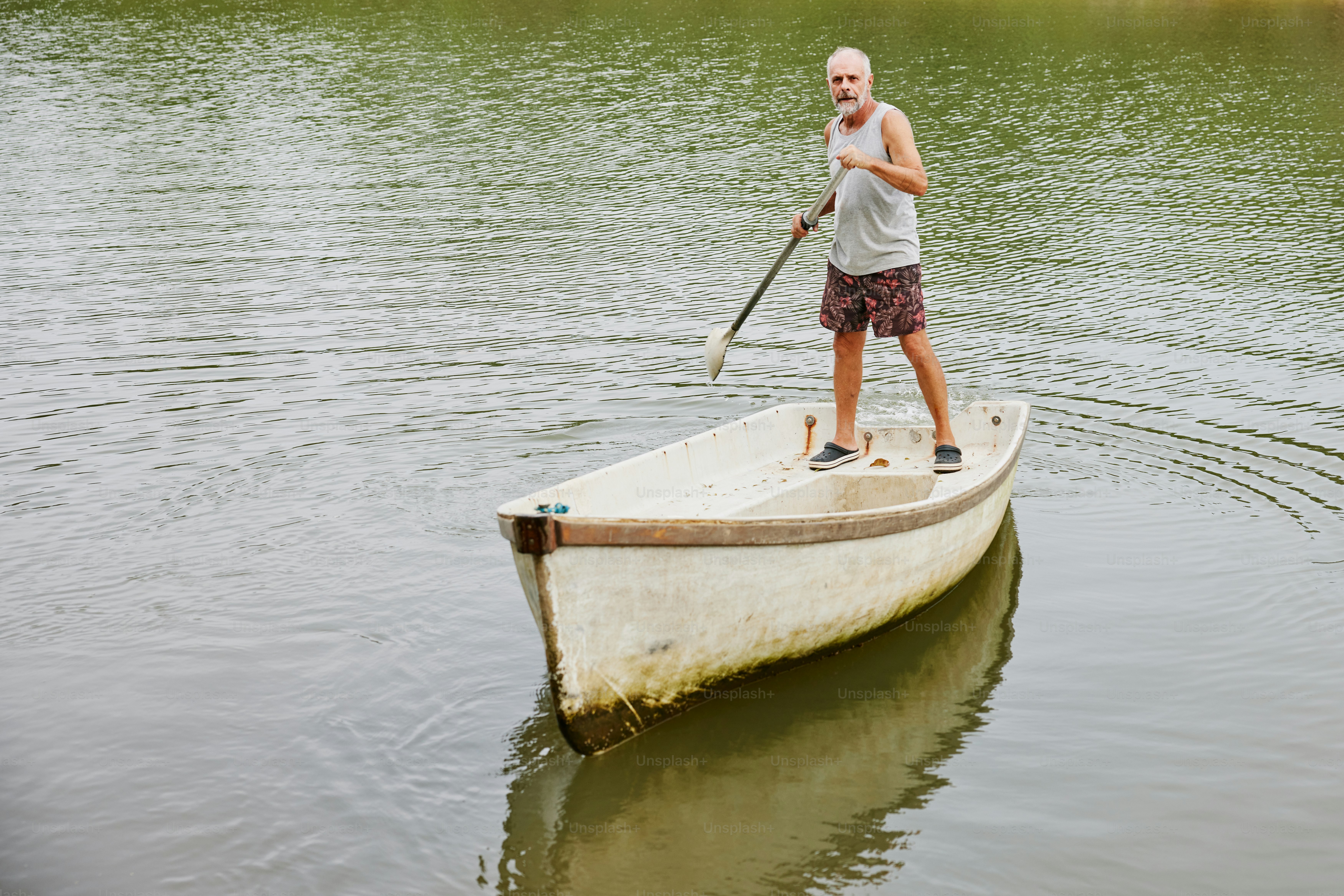 Un hombre rema un bote en un lago foto – Imagen de Hombre mayor en Unsplash