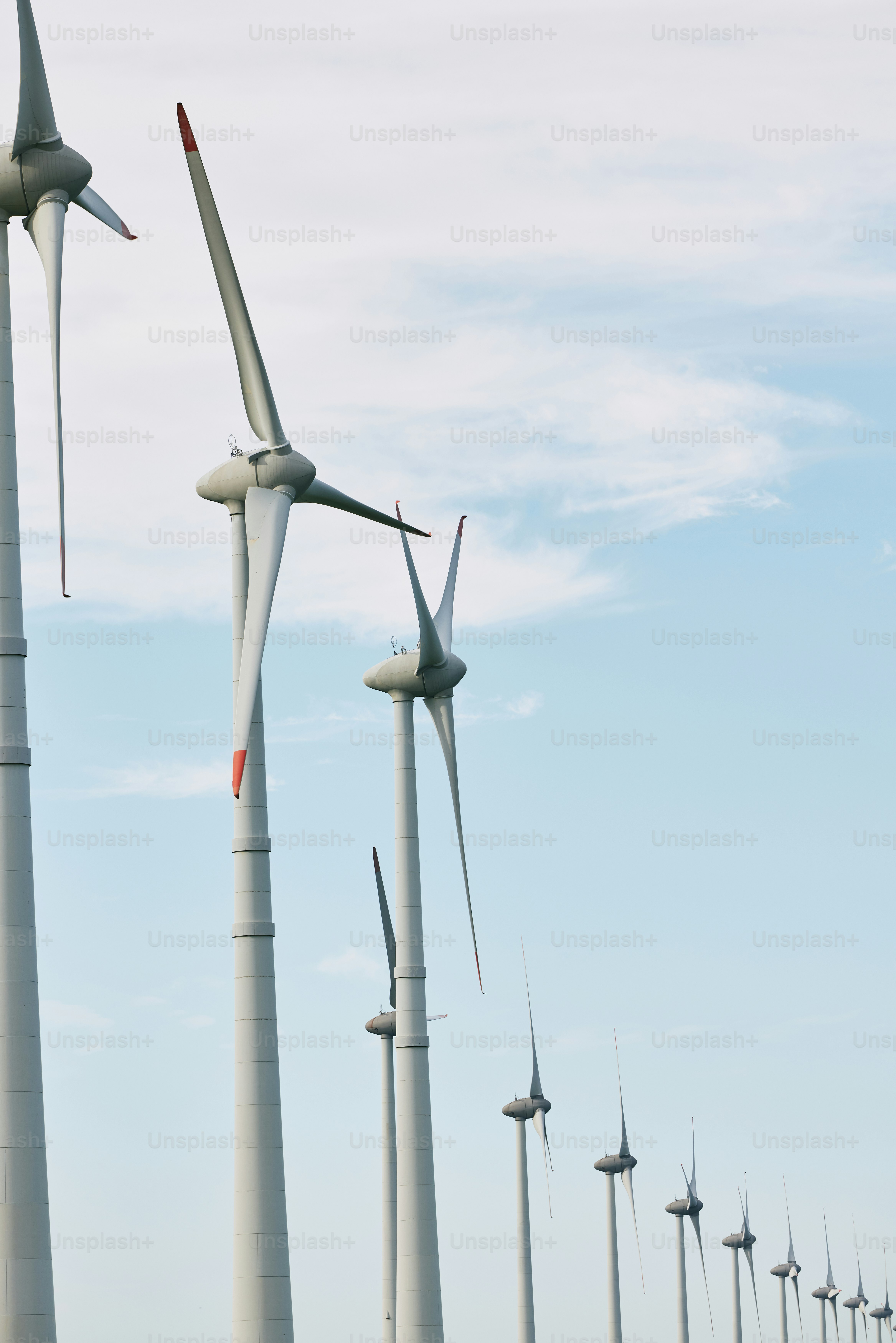 A row of wind turbines in a field photo – Wind farm Image on Unsplash