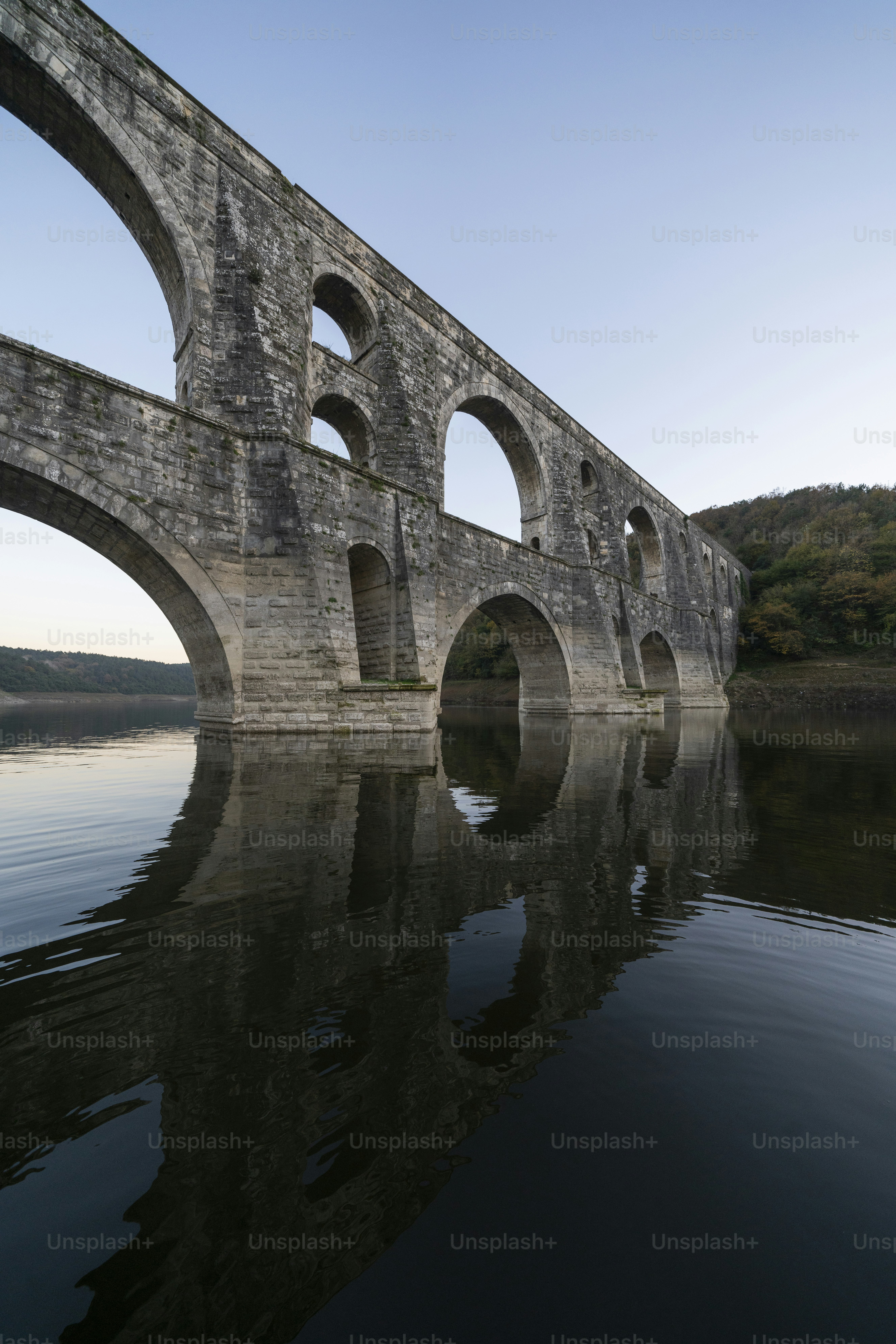 A large stone bridge over a body of water photo – Water Image on Unsplash