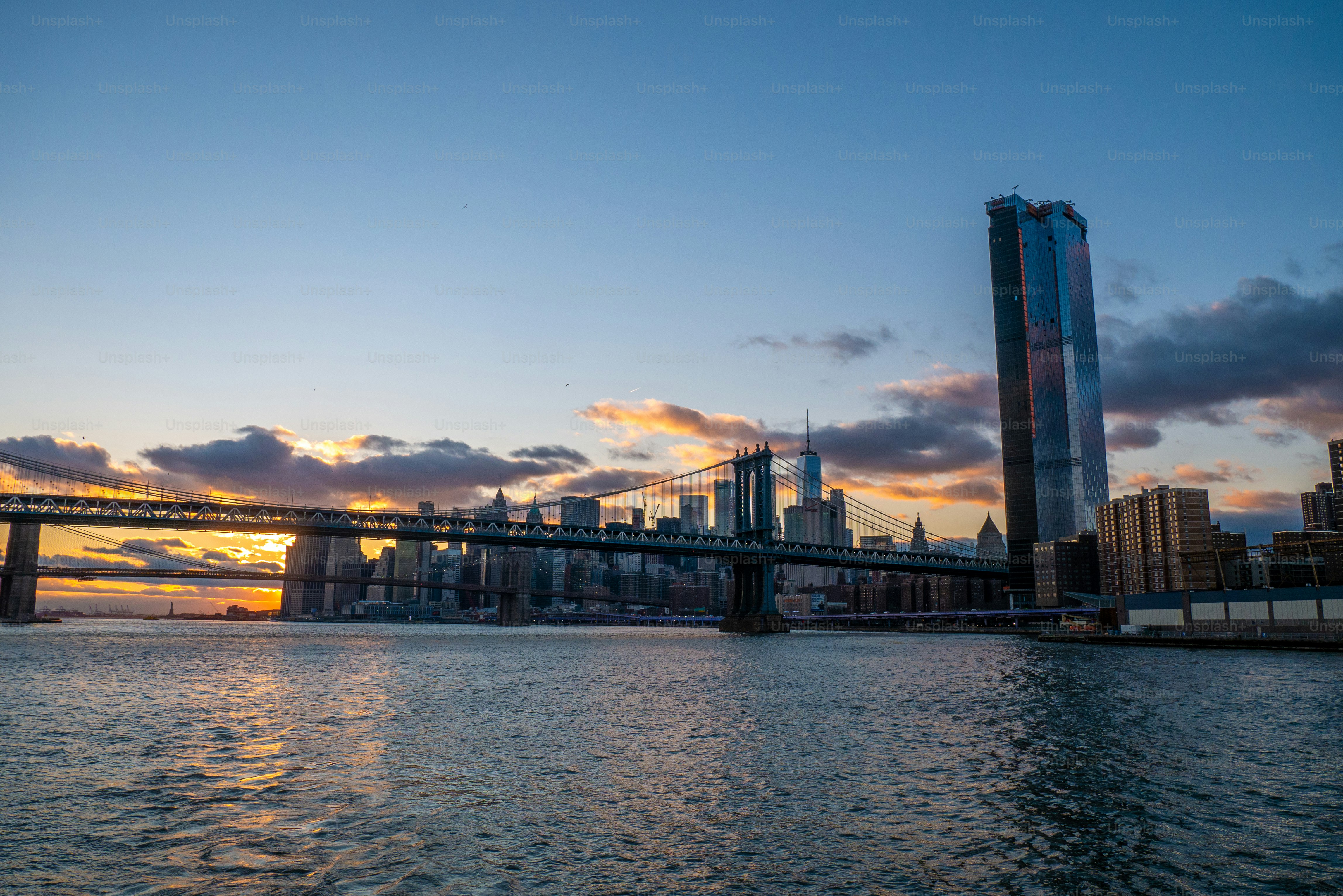 A large bridge spanning over a large body of water photo – Manhattan ...