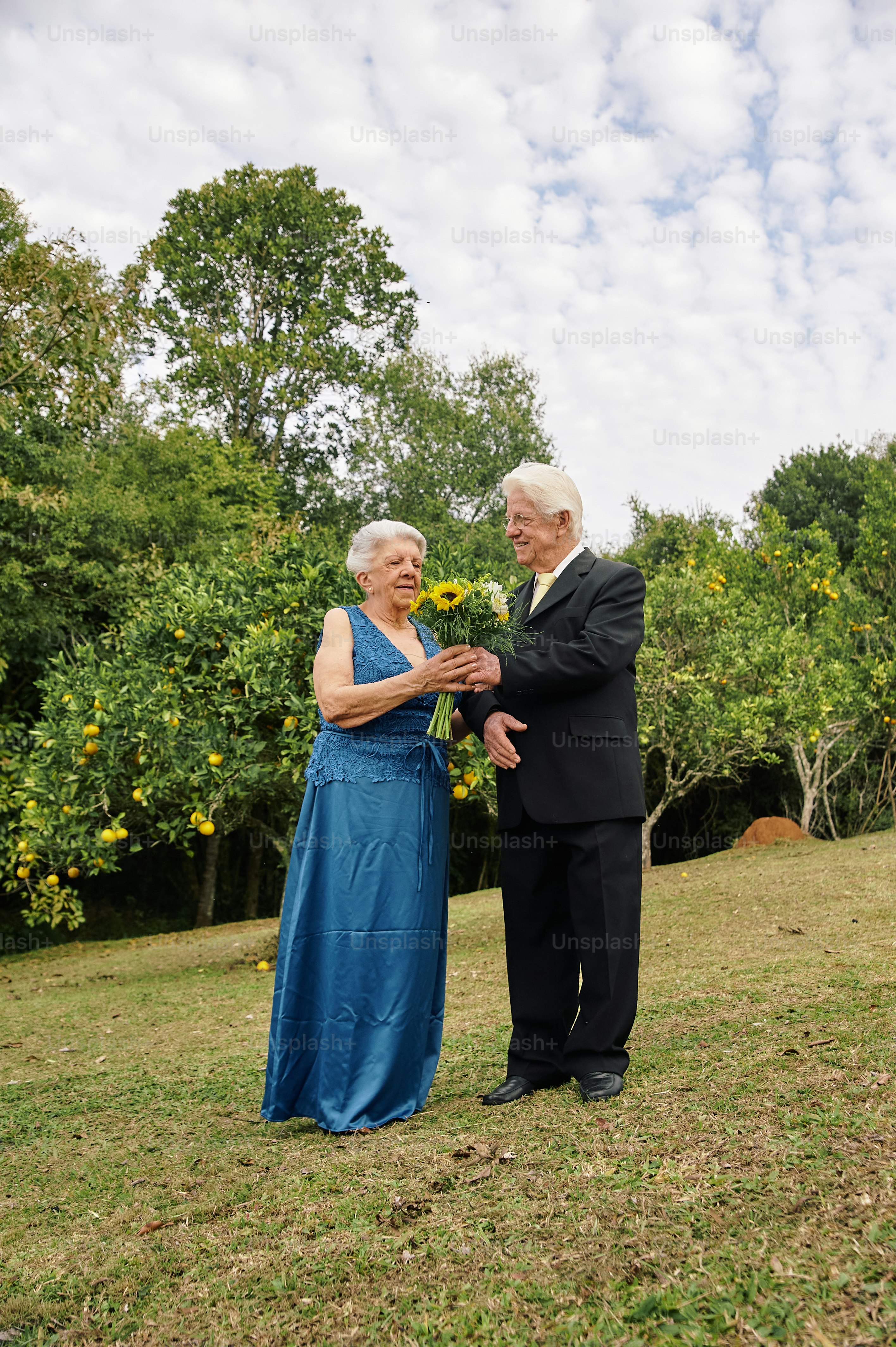 Un homme et une femme debout dans un champ photo – Costume Photo sur ...