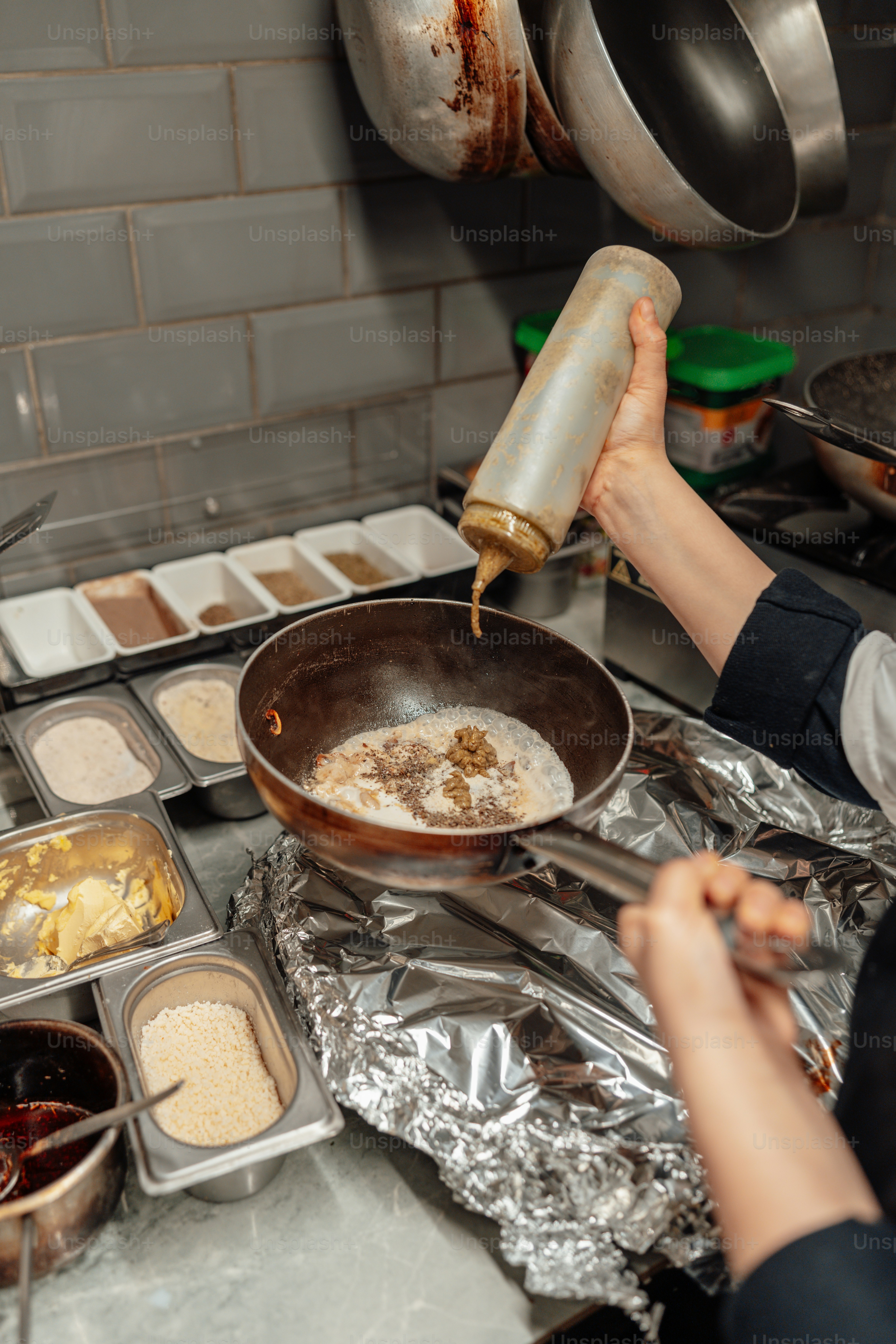A person cooking food in a wok on a stove photo – Frying pan Image on ...