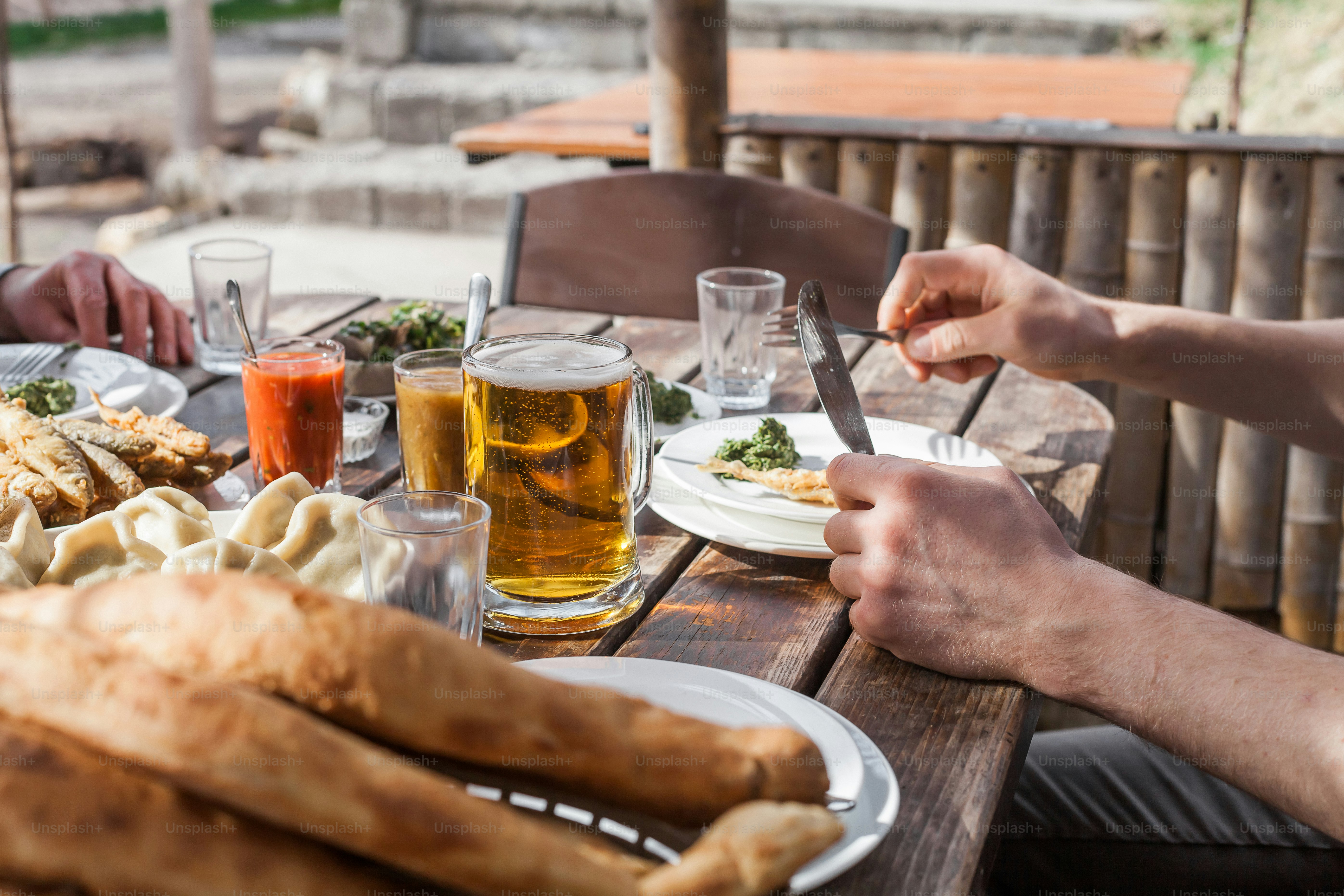 A couple of people sitting at a table with plates of food photo – Food ...