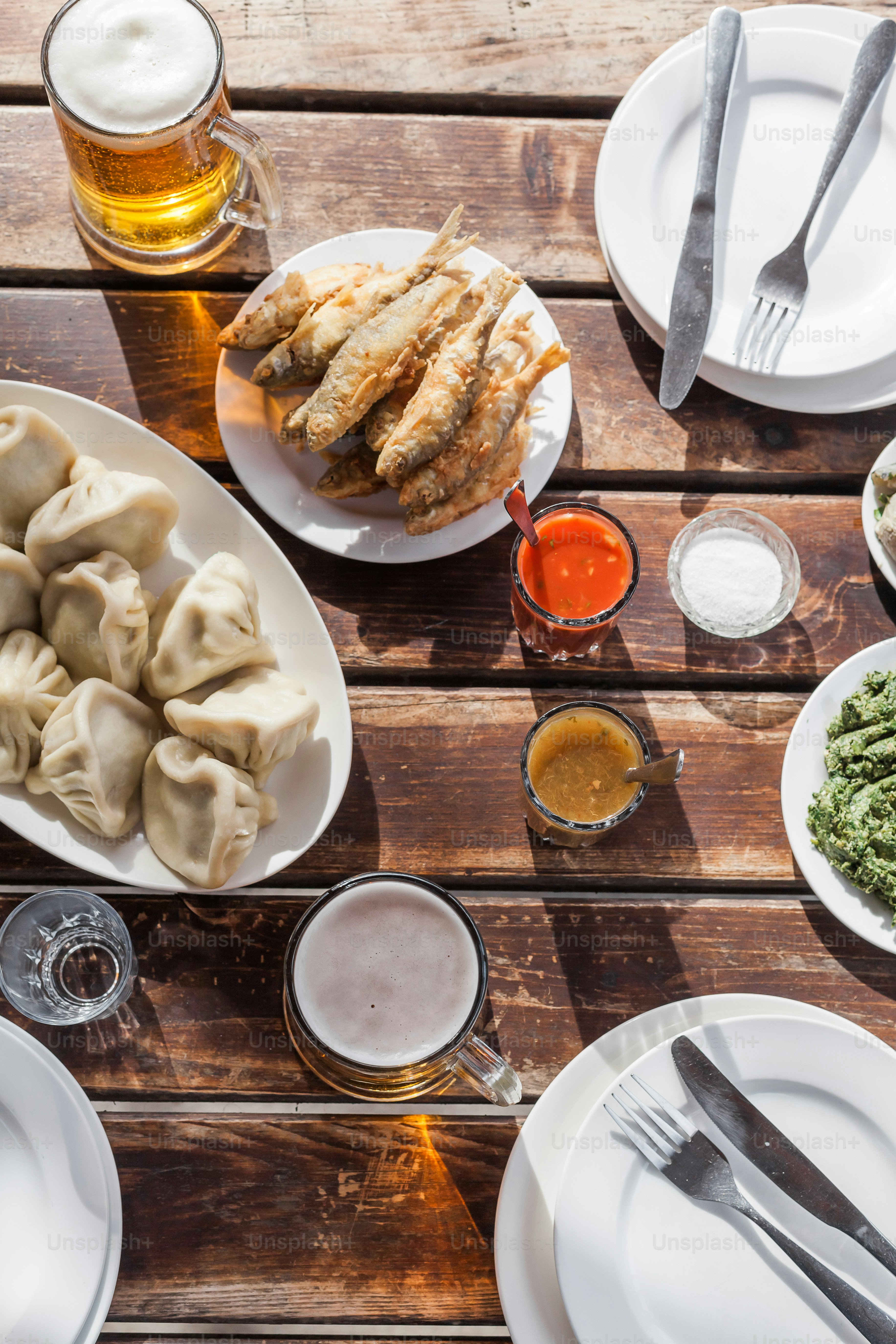 A couple of people sitting at a table with plates of food photo – Food ...