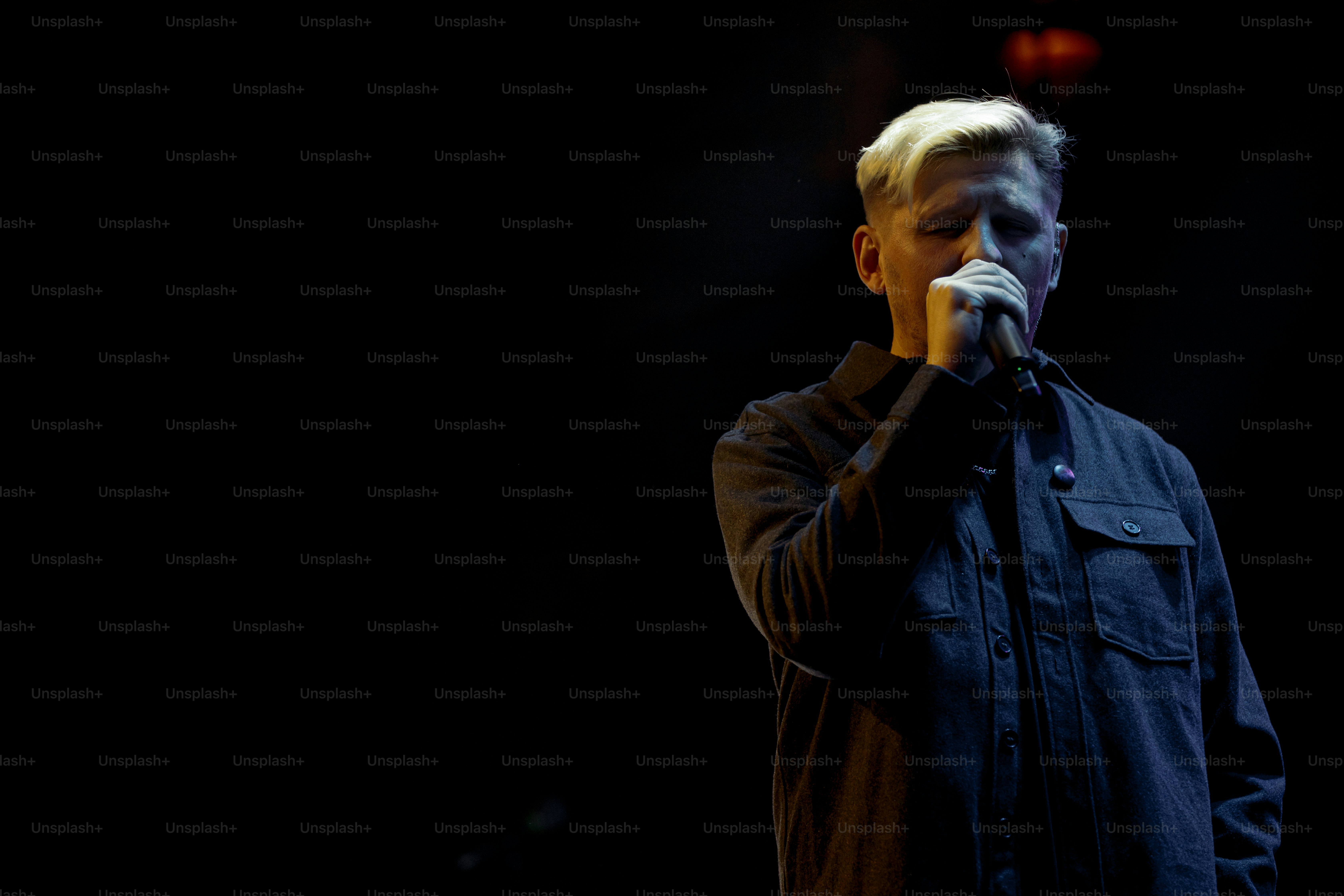 A man with a microphone in his hand photo – Vocalist Image on Unsplash