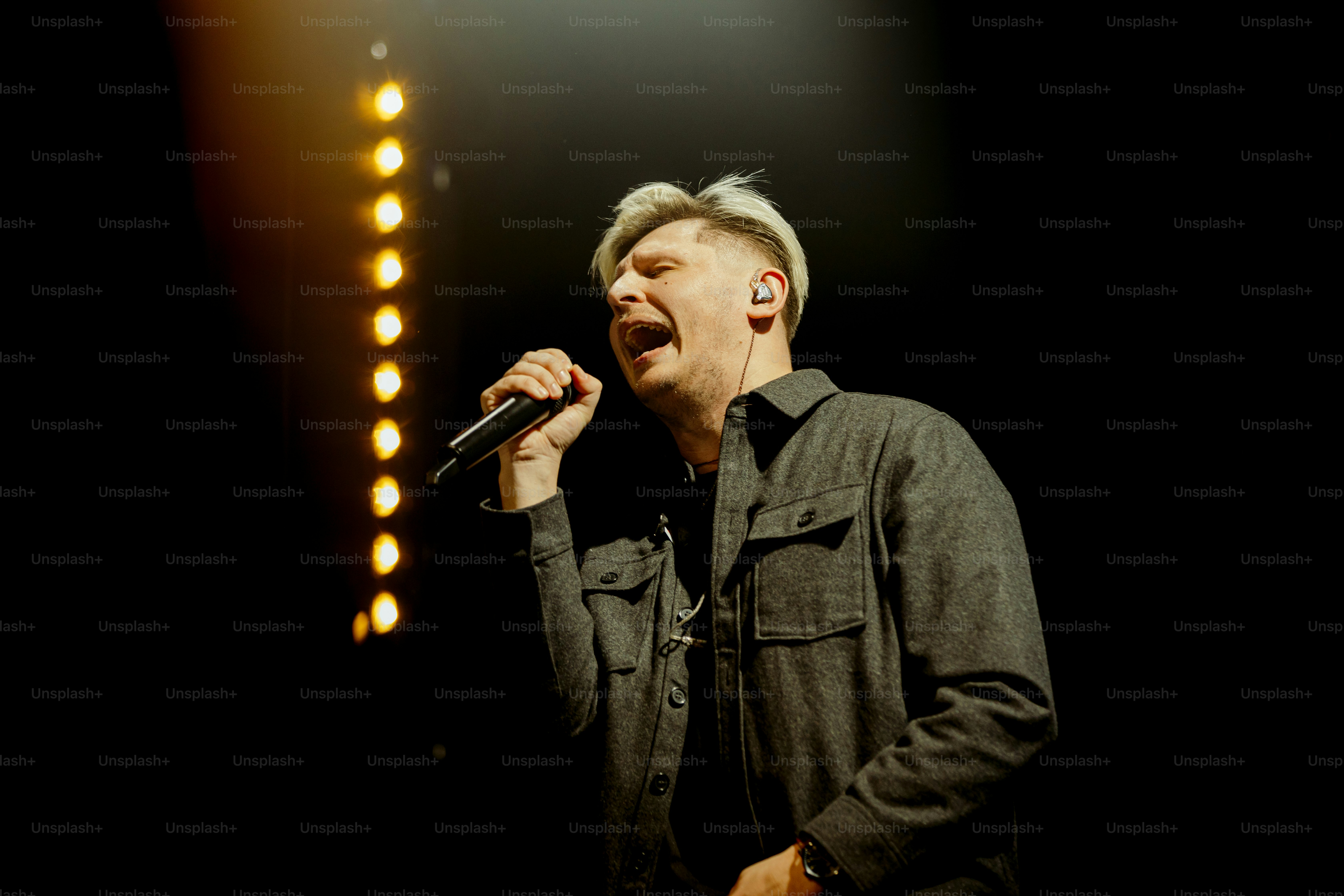 A man singing into a microphone on stage photo – Concert Image on Unsplash