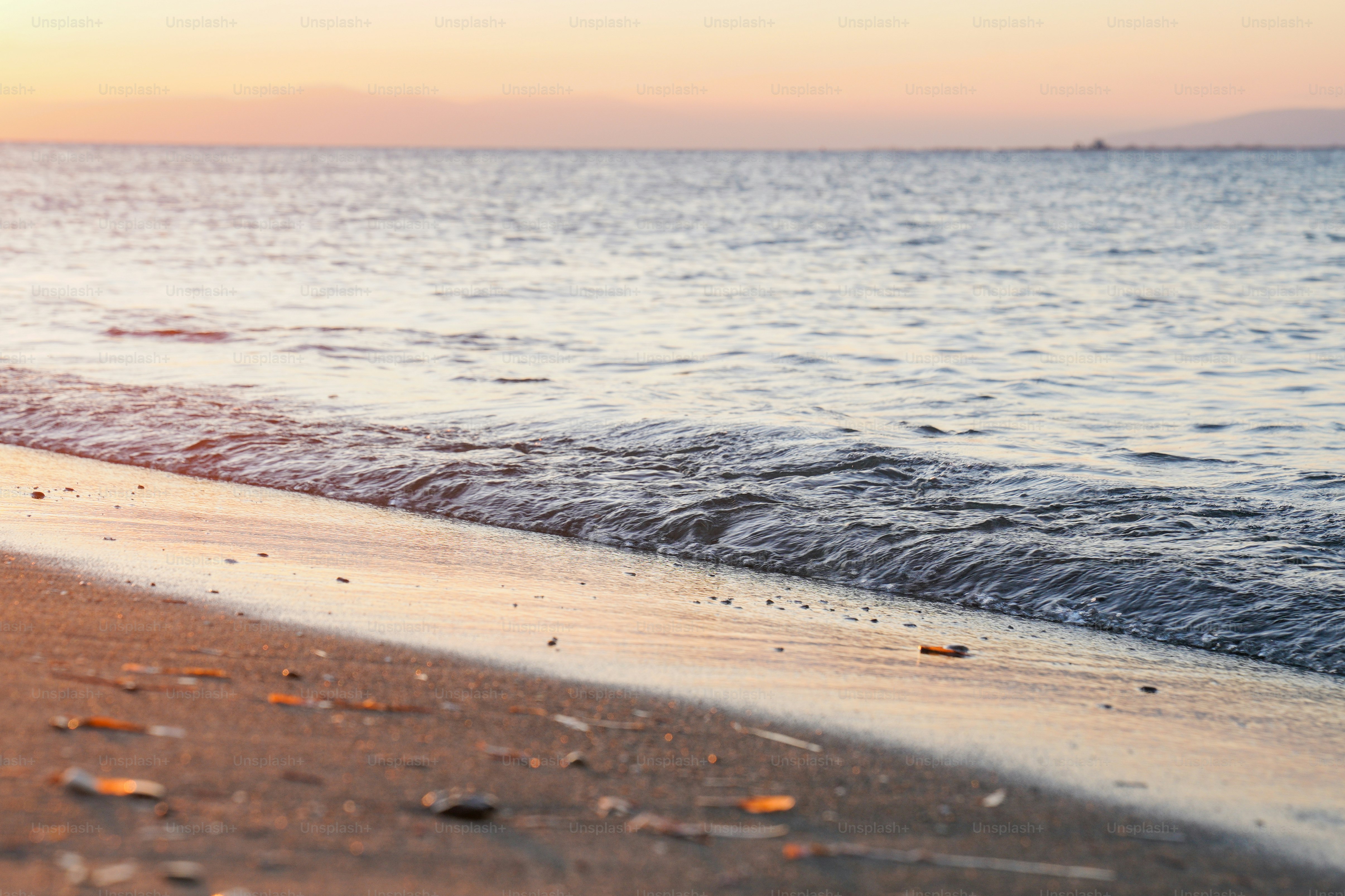 Foto zum Thema Ein Sandstrand mit Wellen, die an Land kommen – Bild zu ...