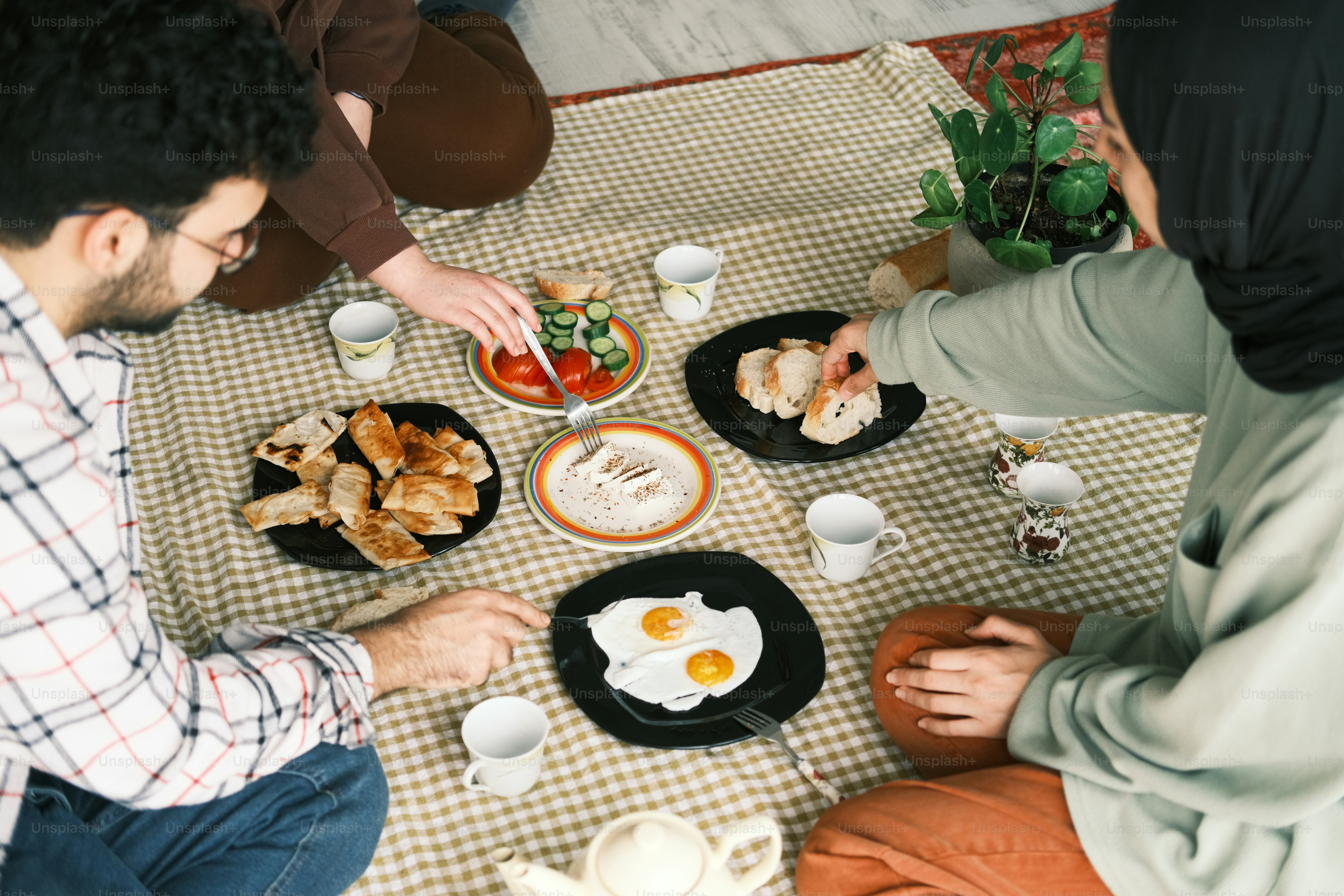 Un groupe de personnes assises autour d’une table en train de manger de ...