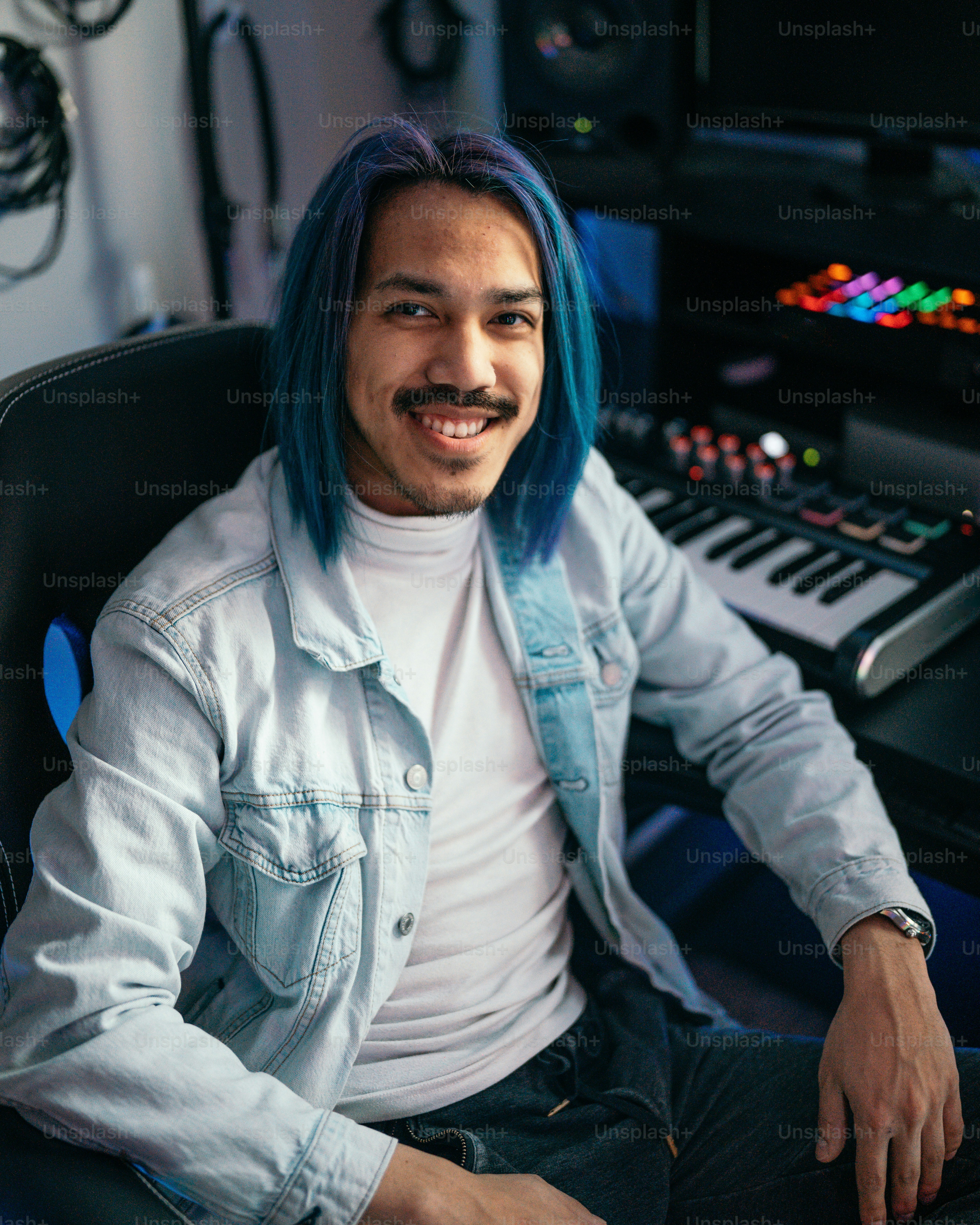 Foto Un hombre con cabello azul sentado frente a un teclado – Productor ...
