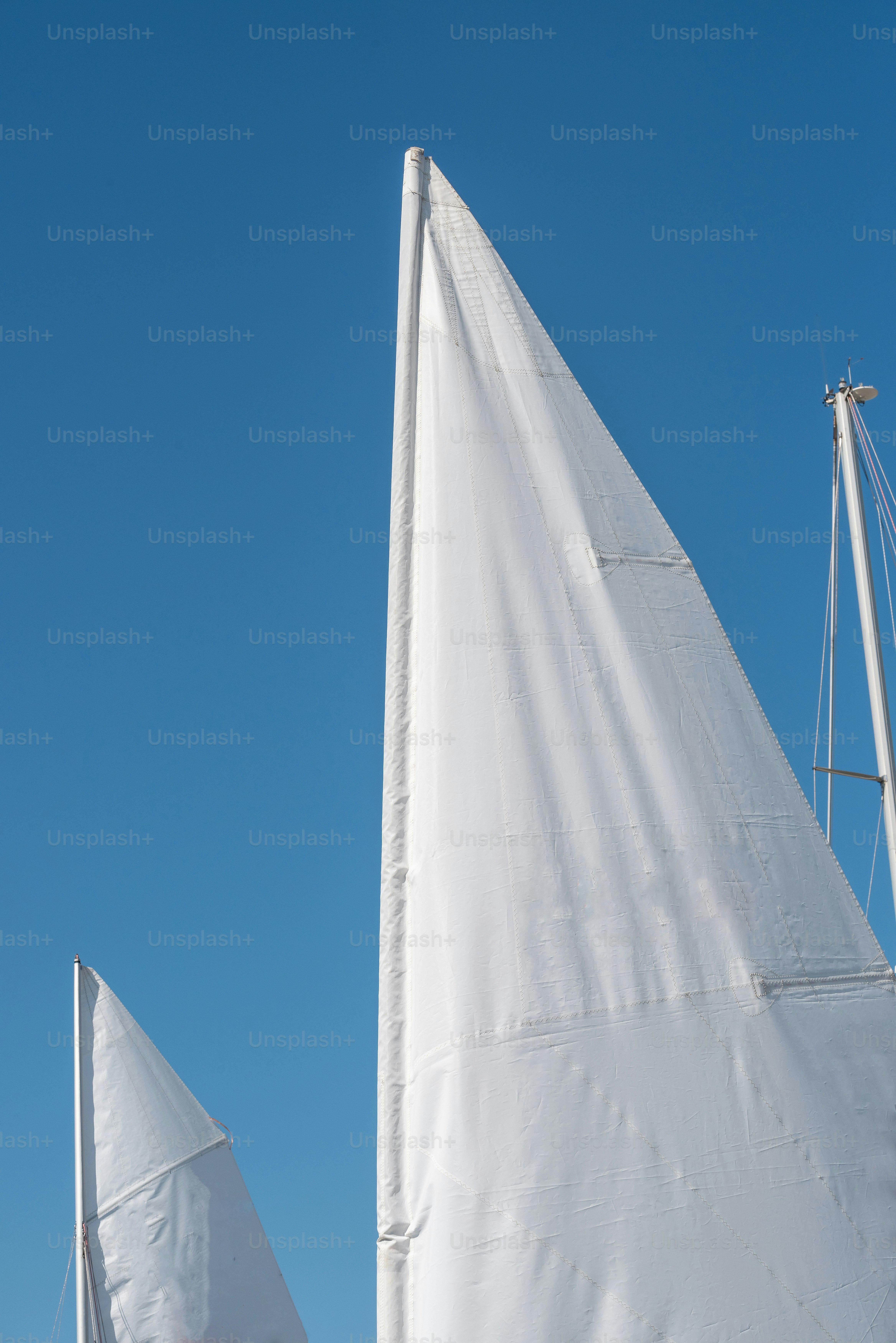 A couple of white sail boats sitting next to each other photo ...