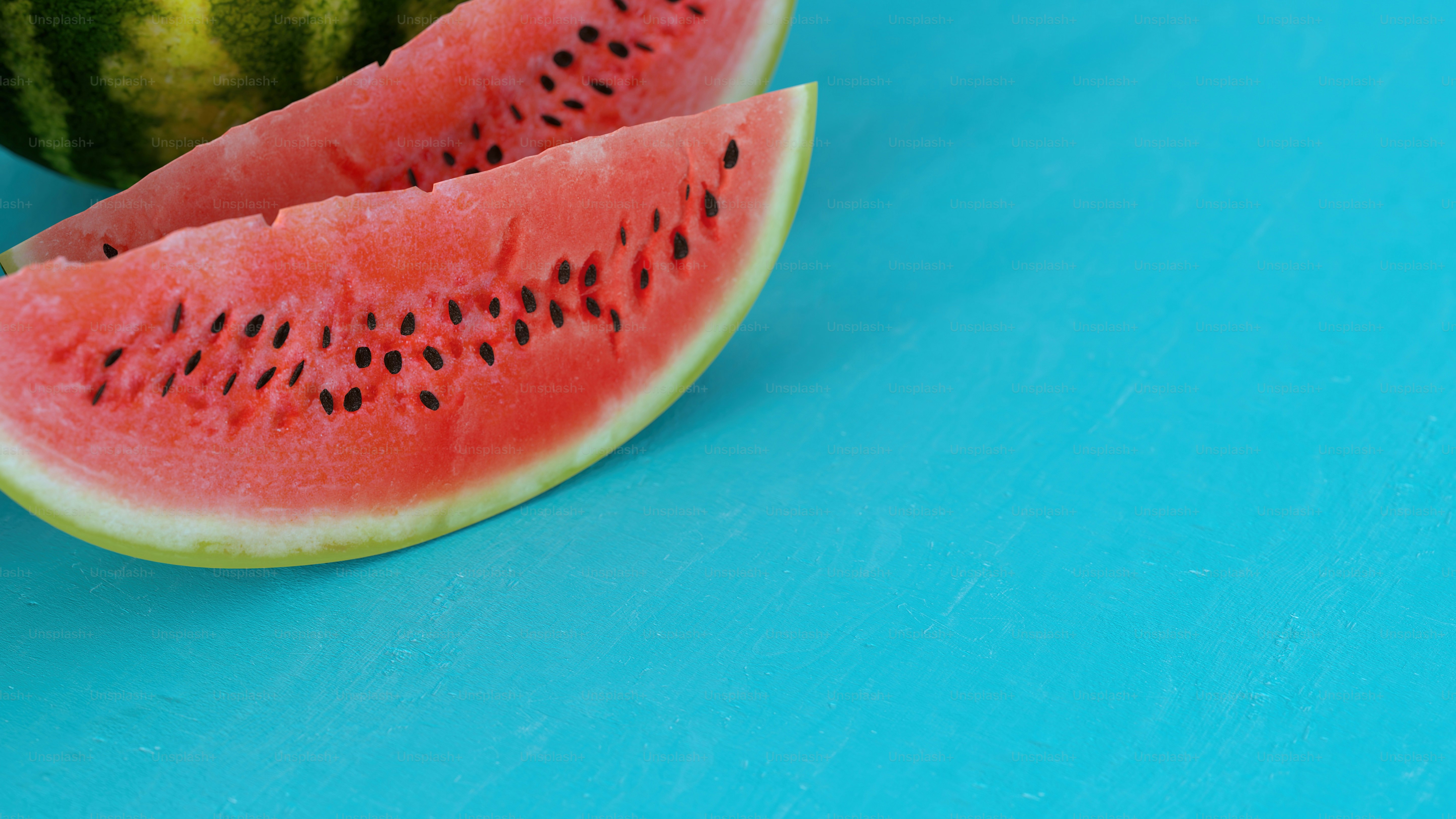 Foto Dos trozos de sandía sobre una superficie azul – Sandía Imagen en ...