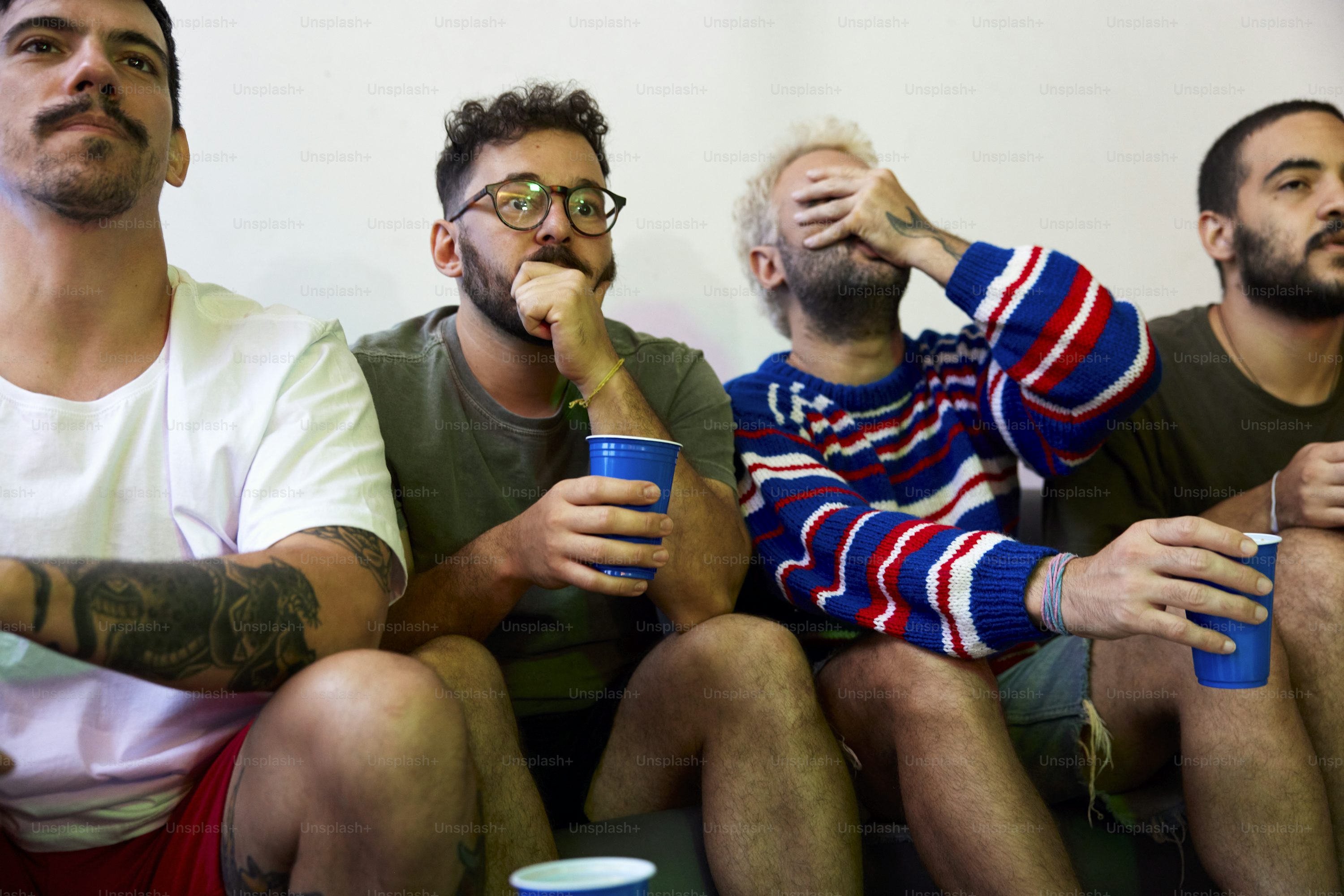 A group of men sitting next to each other photo – Men watching tv Image ... A group of men sitting next to each other photo – Men watching tv Image ...