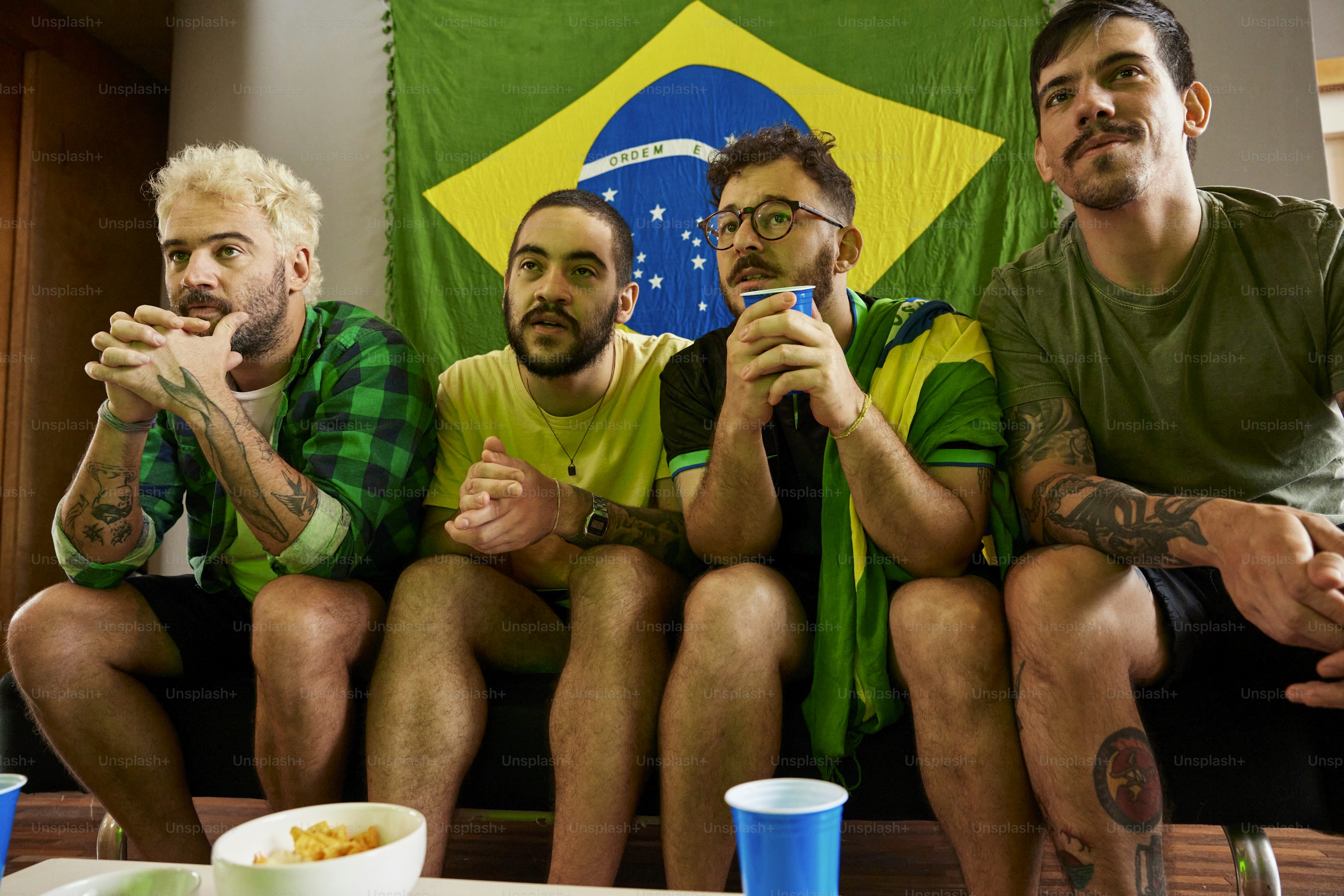 A group of men sitting next to each other photo – Watching tv Image on ... A group of men sitting next to each other photo – Watching tv Image on ...