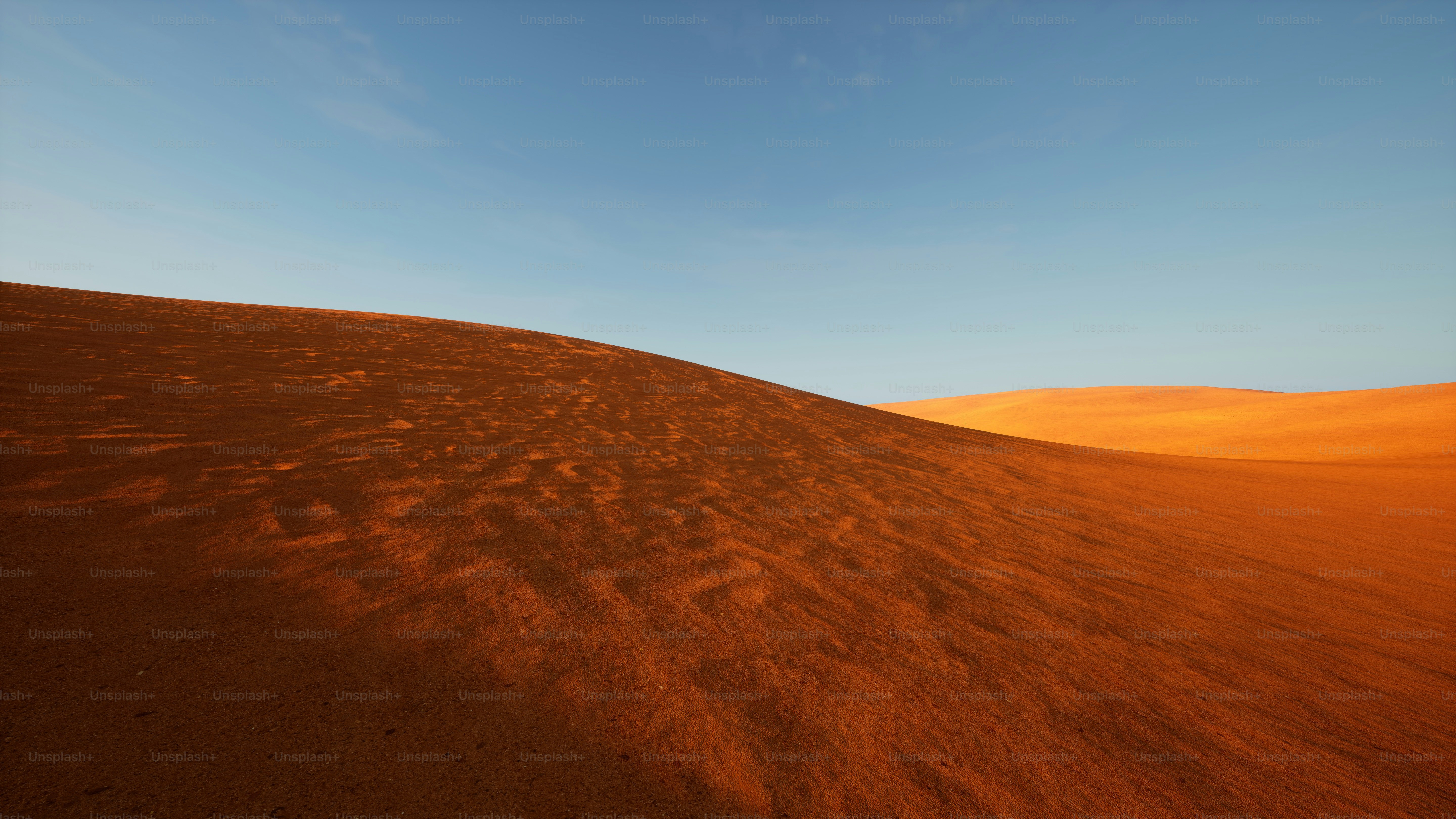 An orange sand dune with a blue sky in the background photo – Background Image on Unsplash