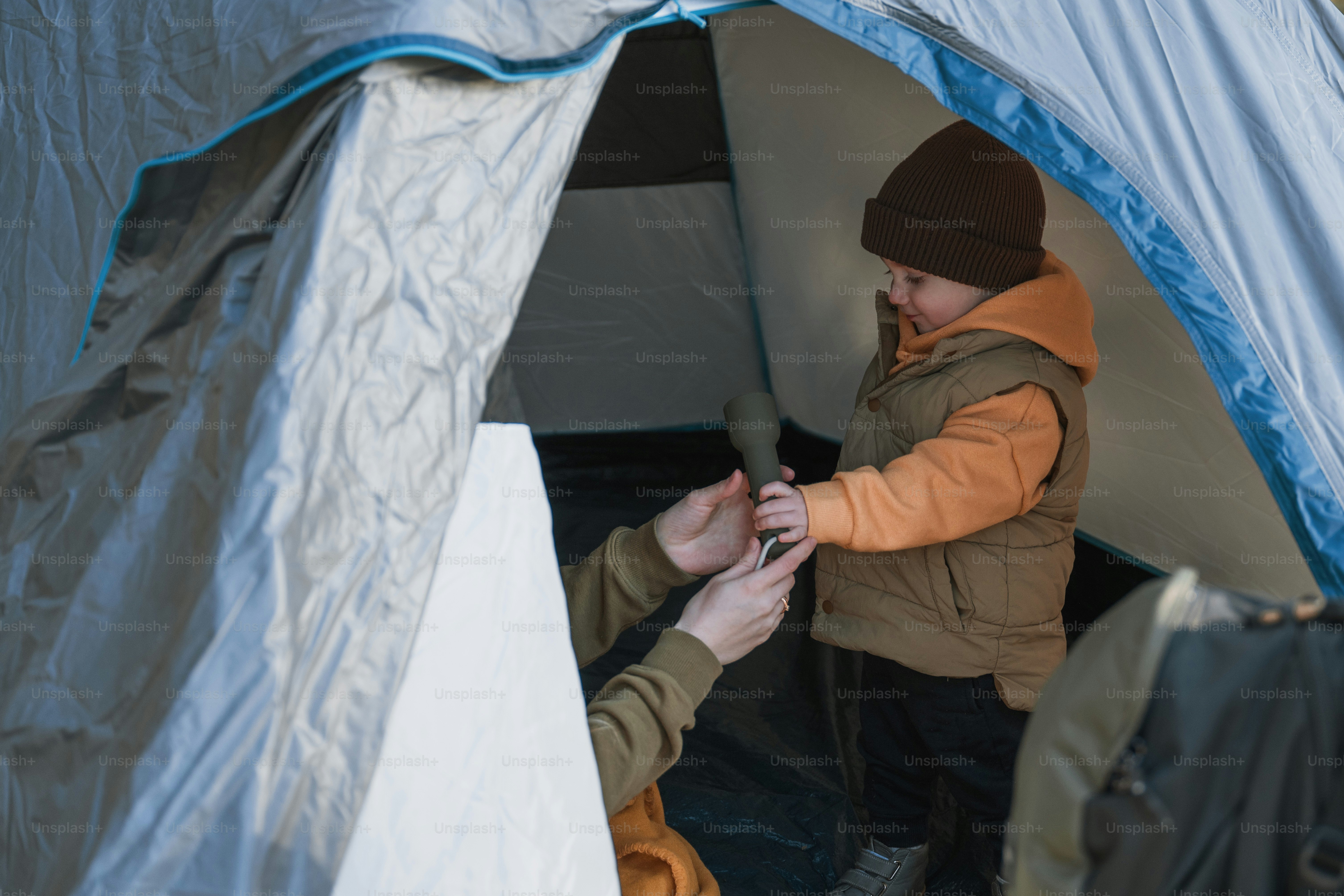 A person in a tent putting something in a person's hand photo – Woods ...