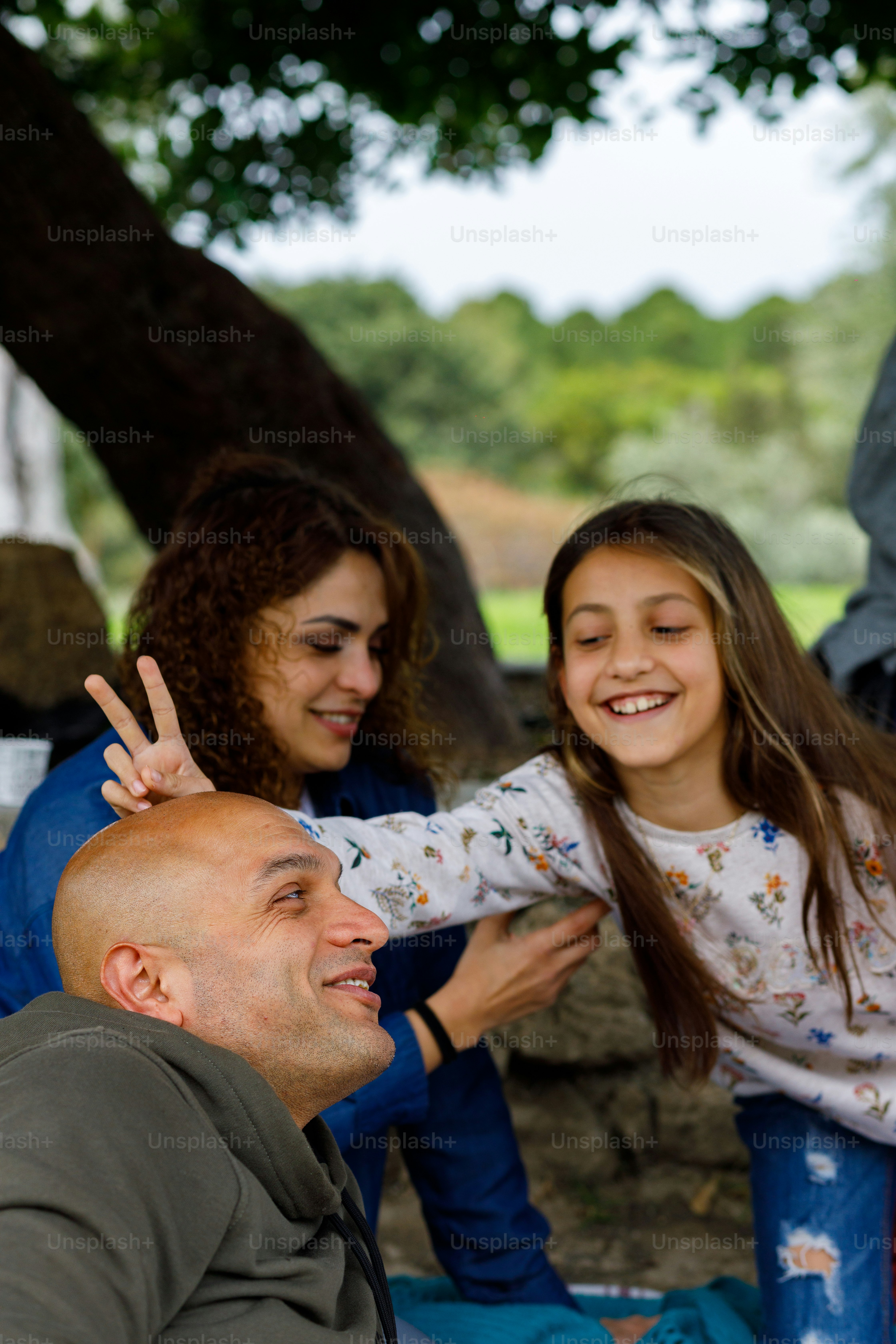 A group of people sitting around each other photo – Outdoor Image on ...