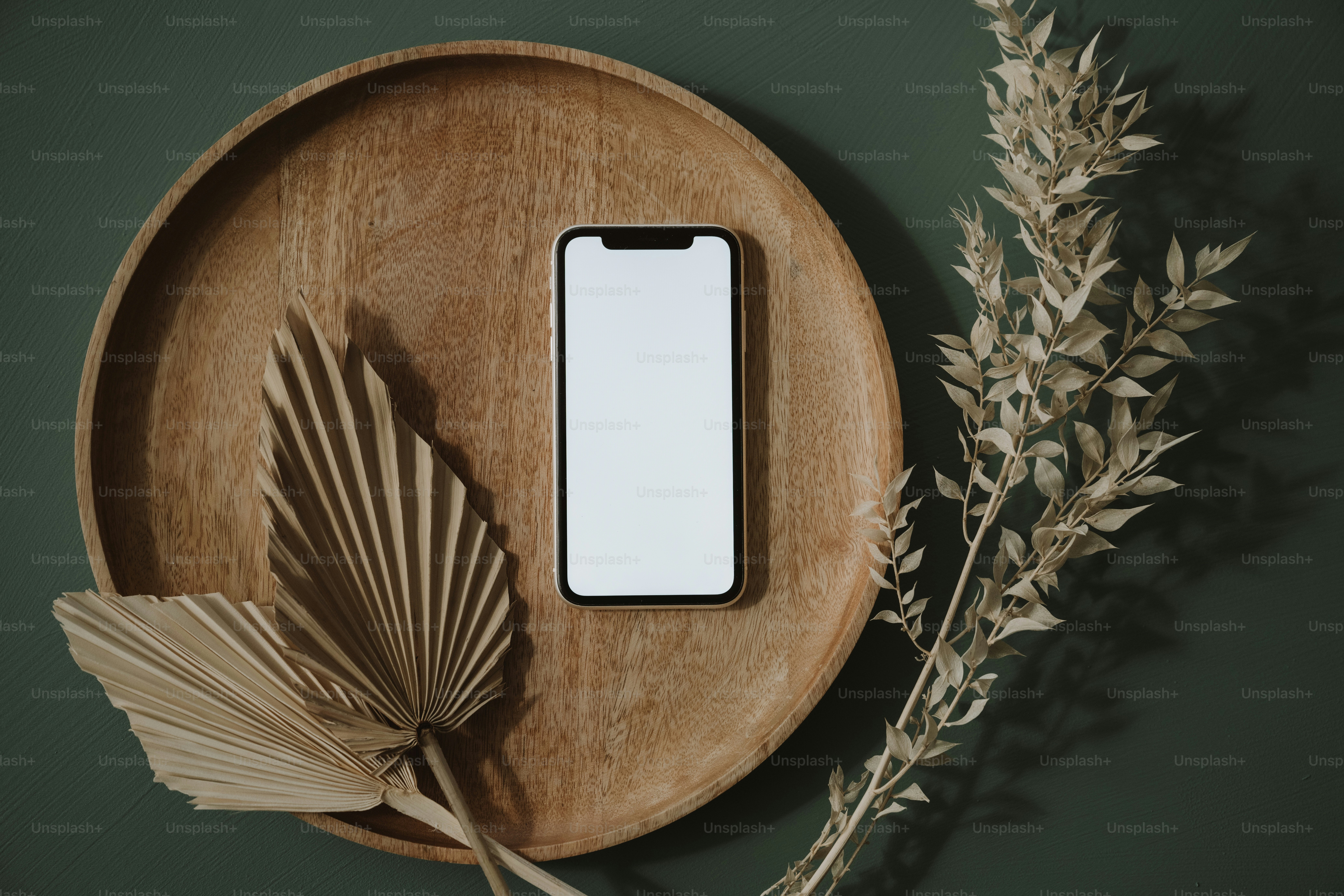 A cell phone sitting on top of a wooden plate photo – Mockup Image on ...