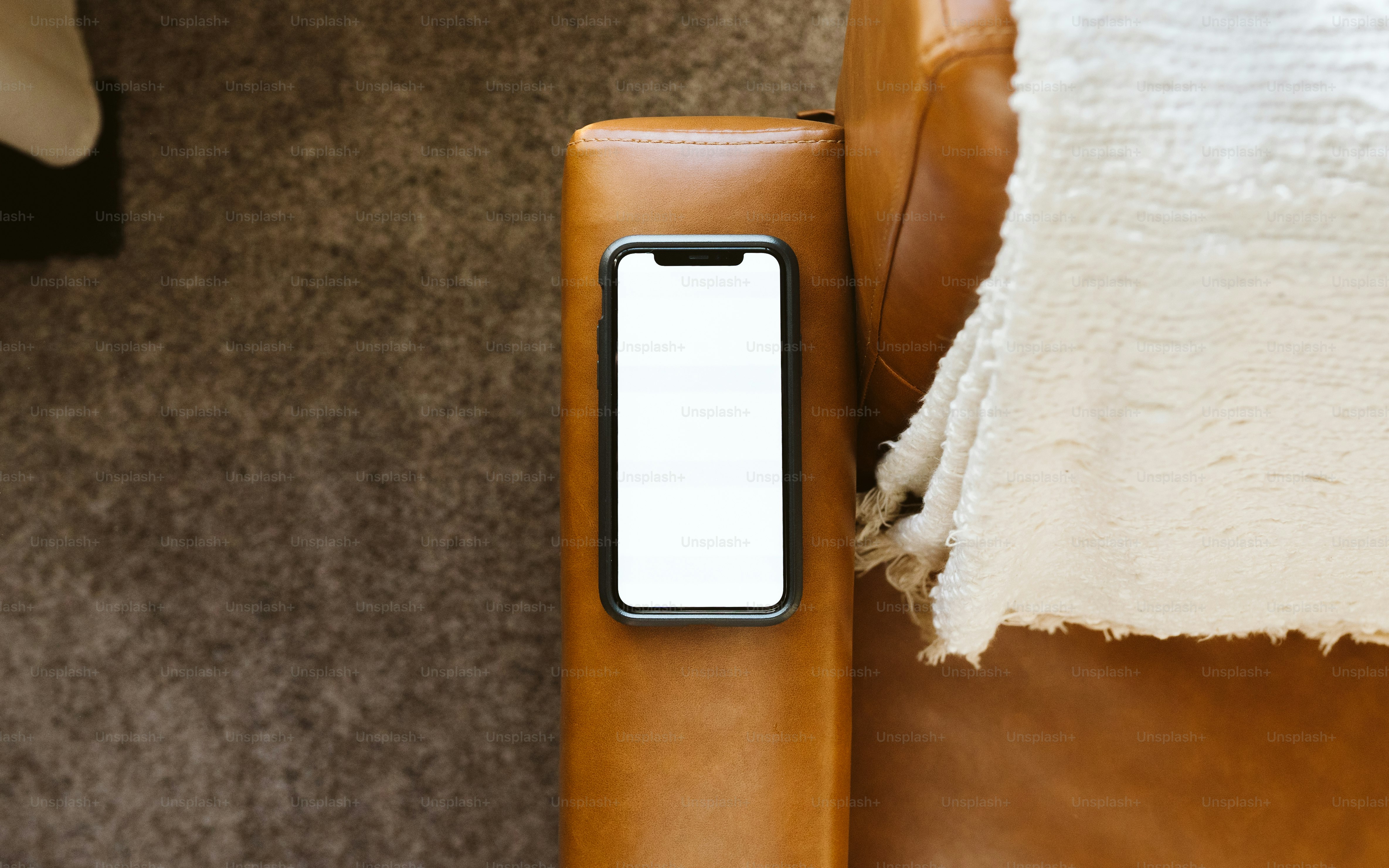 A cell phone sitting on a leather couch photo – Smartphone screen Image ...