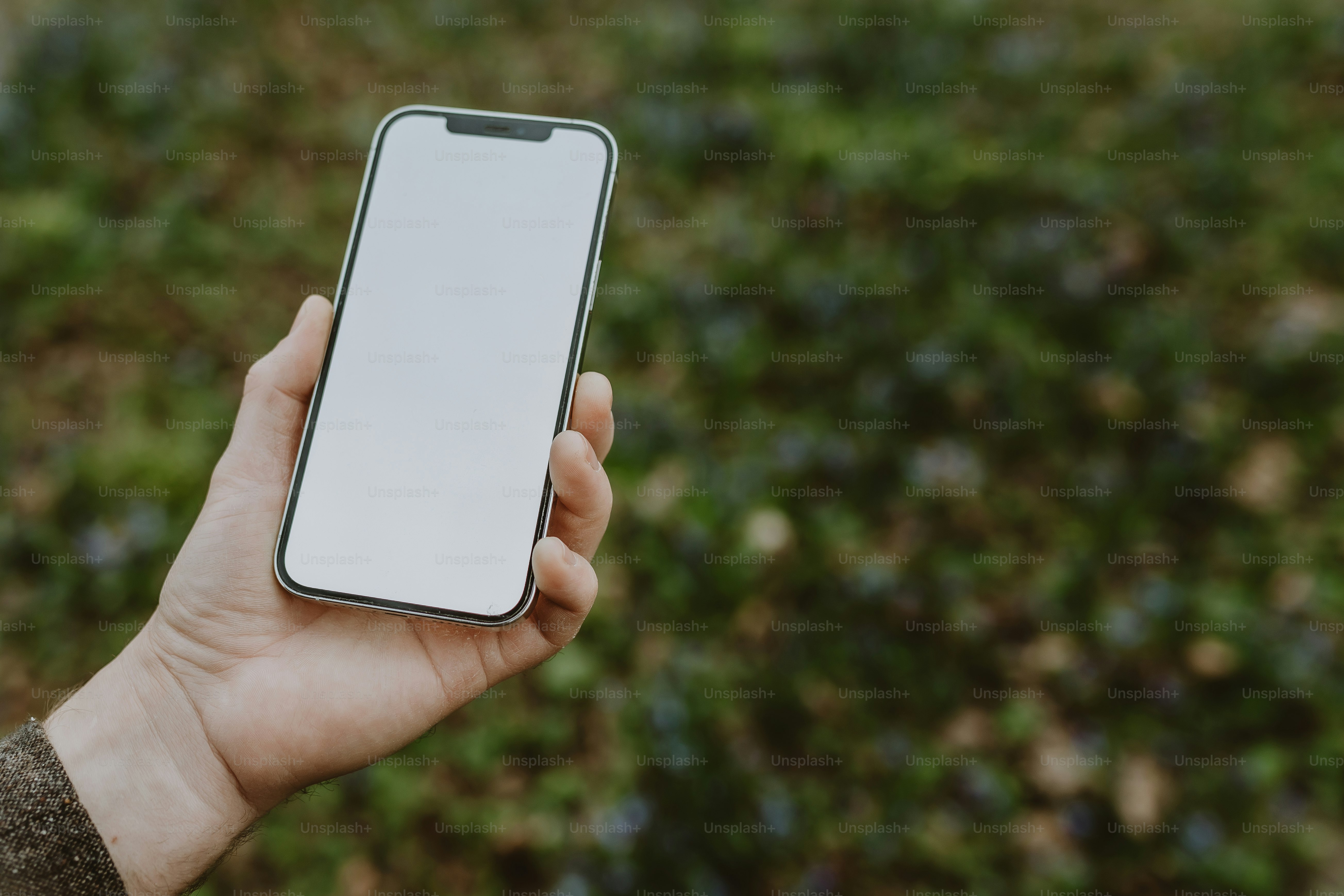 Una persona che tiene un telefono cellulare in mano foto – Immagine di ...