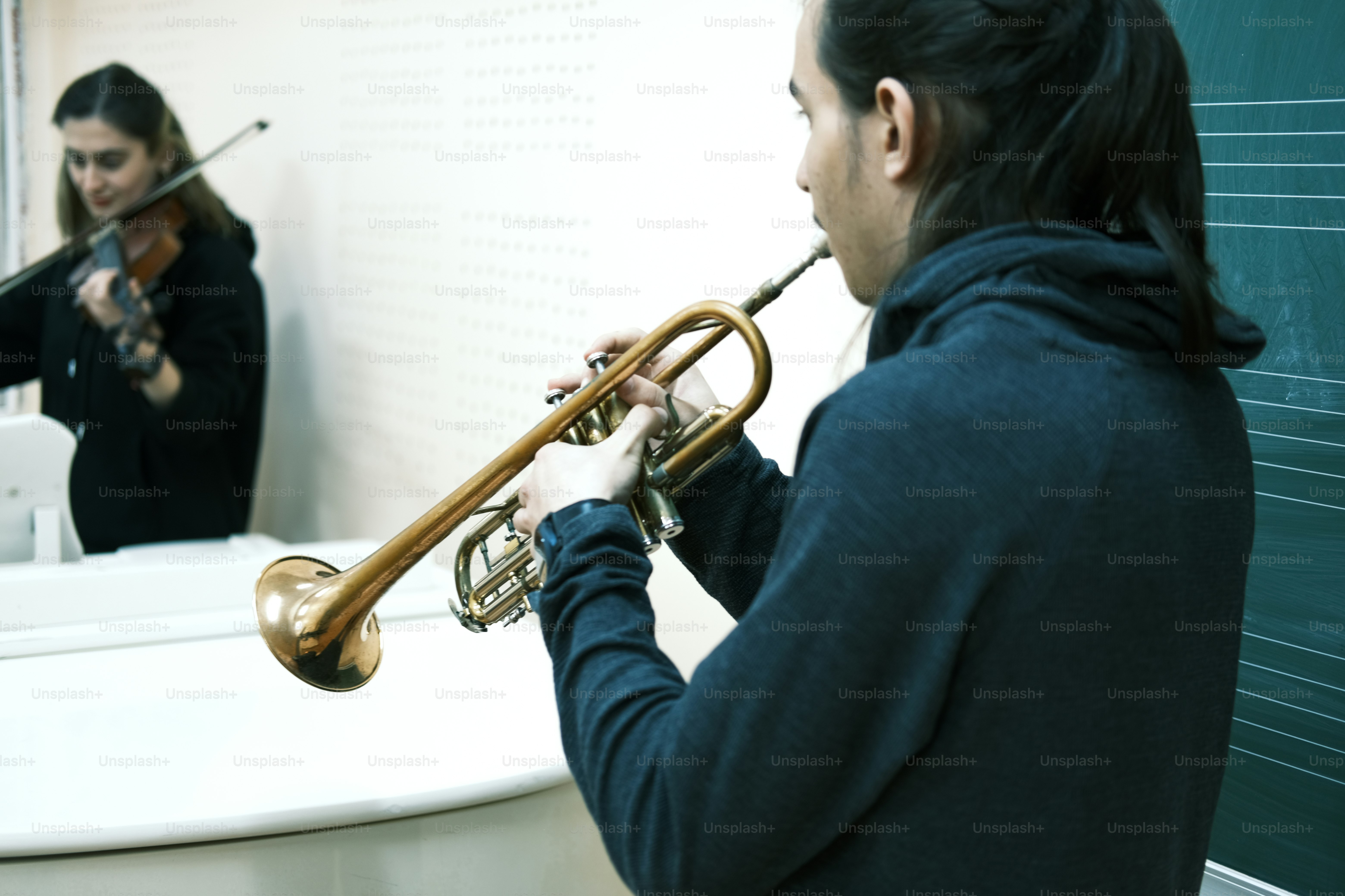 A woman playing a trumpet in front of a mirror photo – Trumpet Image on ...