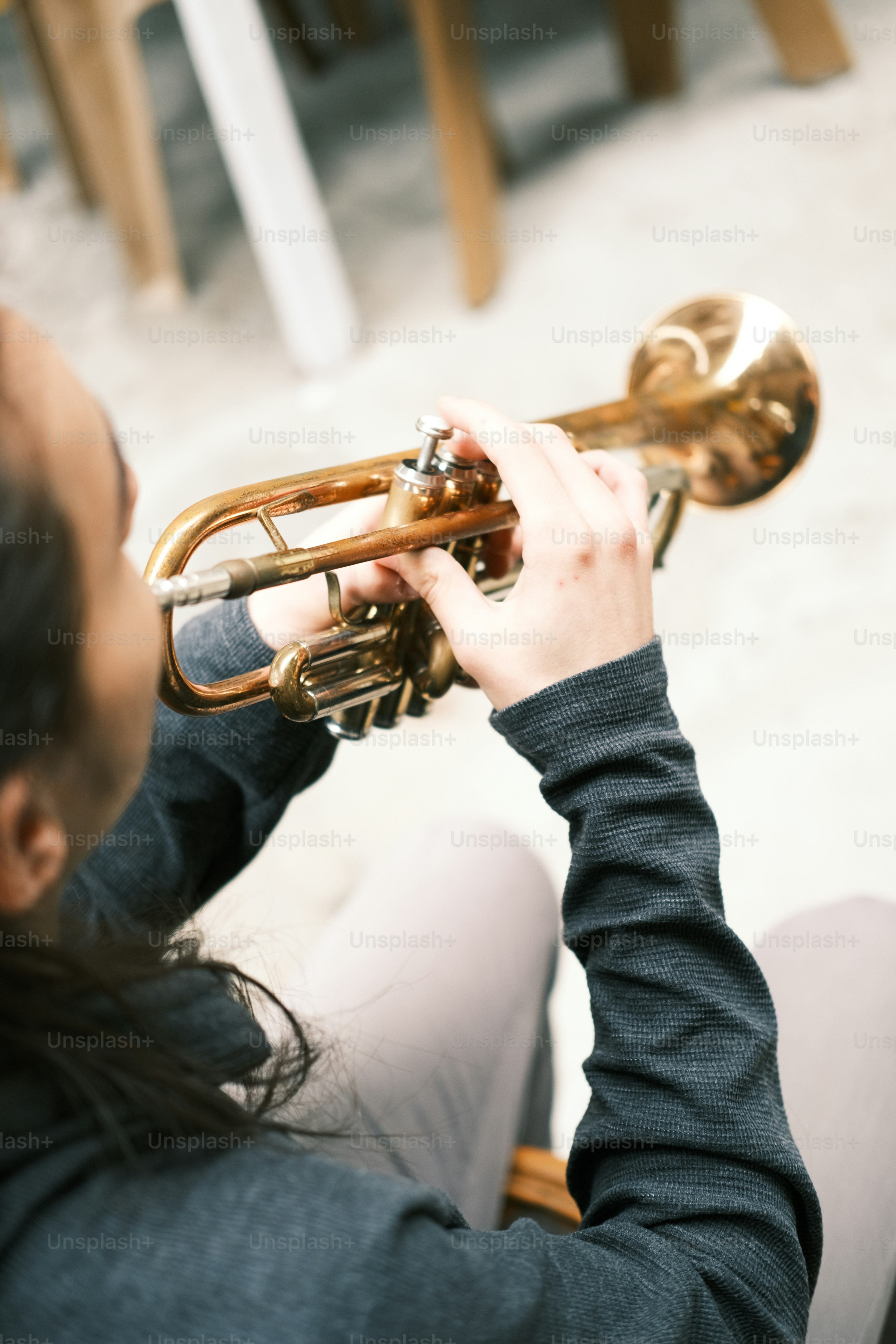 A woman playing a trumpet in a living room photo – Music Image on Unsplash