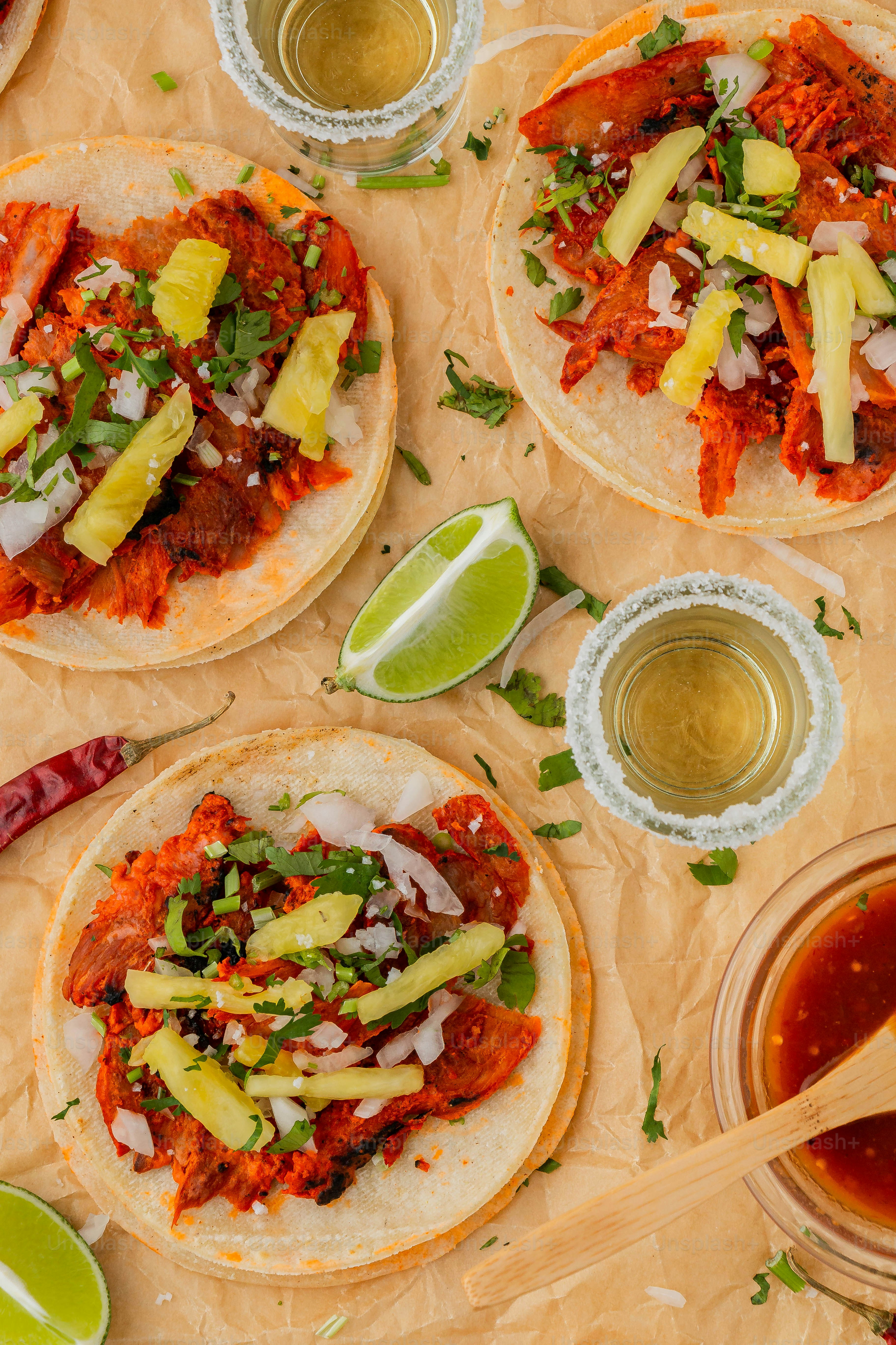 Uma mesa coberta com três tacos cobertos de coberturas foto – Imagem ...