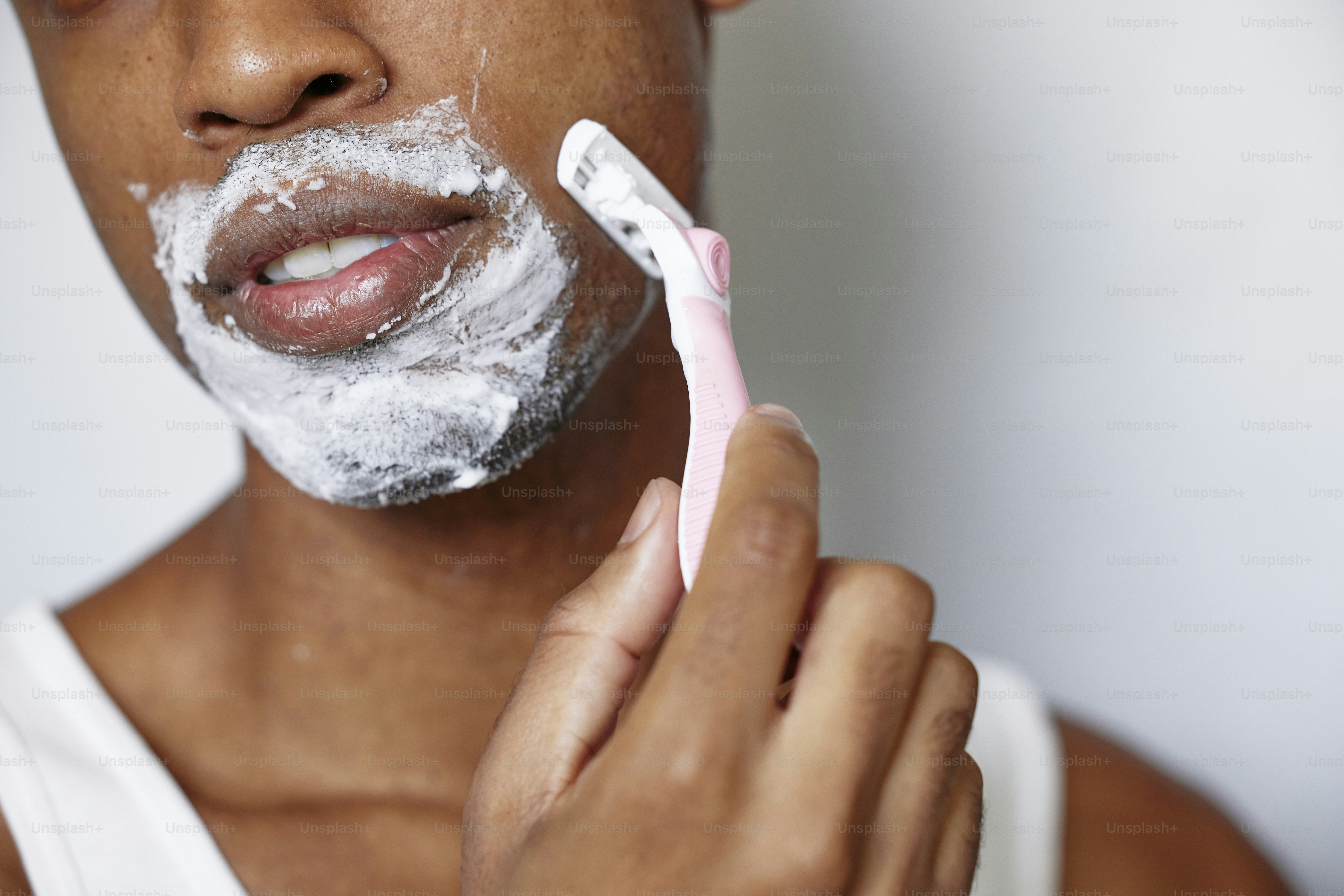A man shaving his face with a razor photo – Beard shaving Image on Unsplash