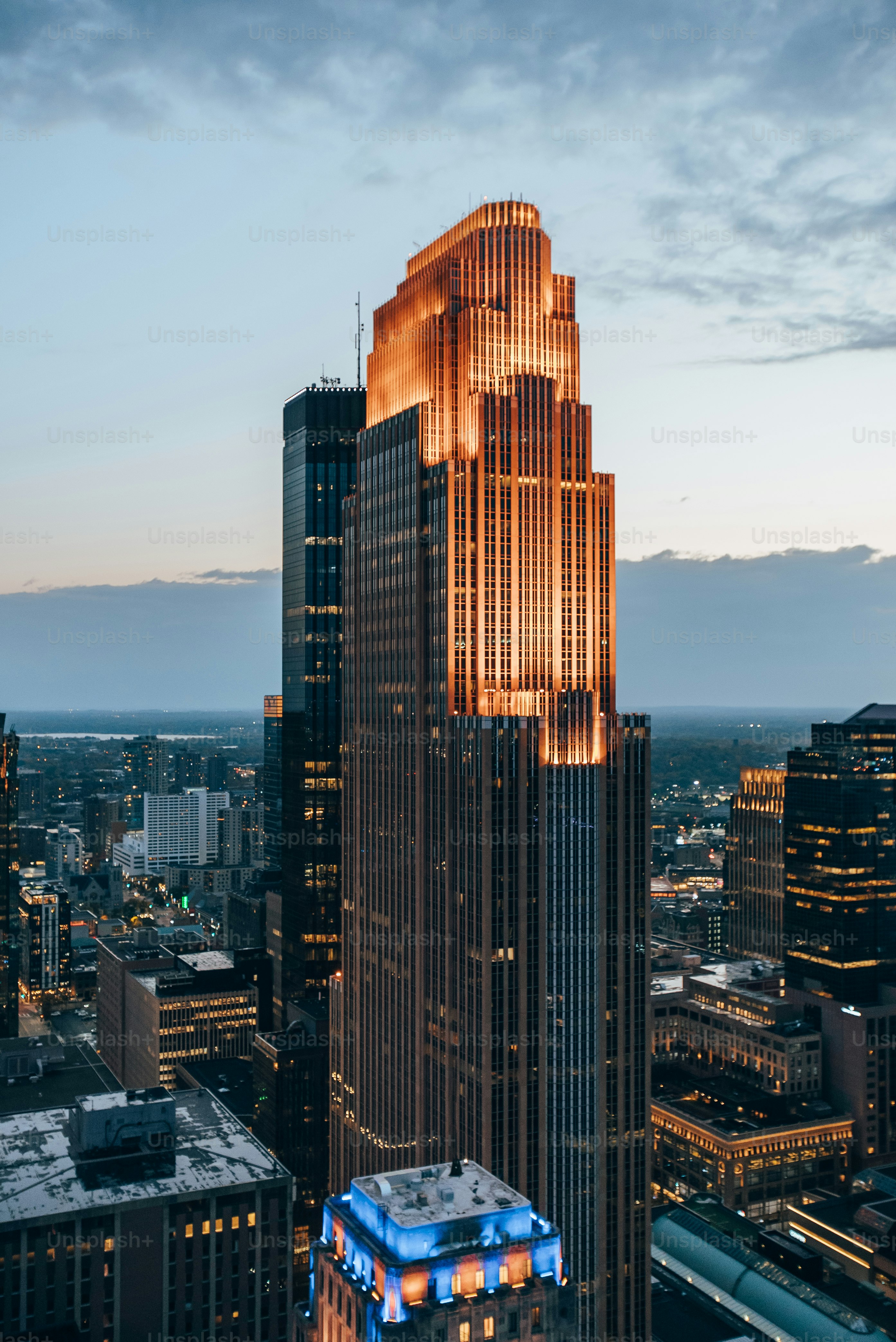 A very tall building with a blue light on it's side photo – Minneapolis ...